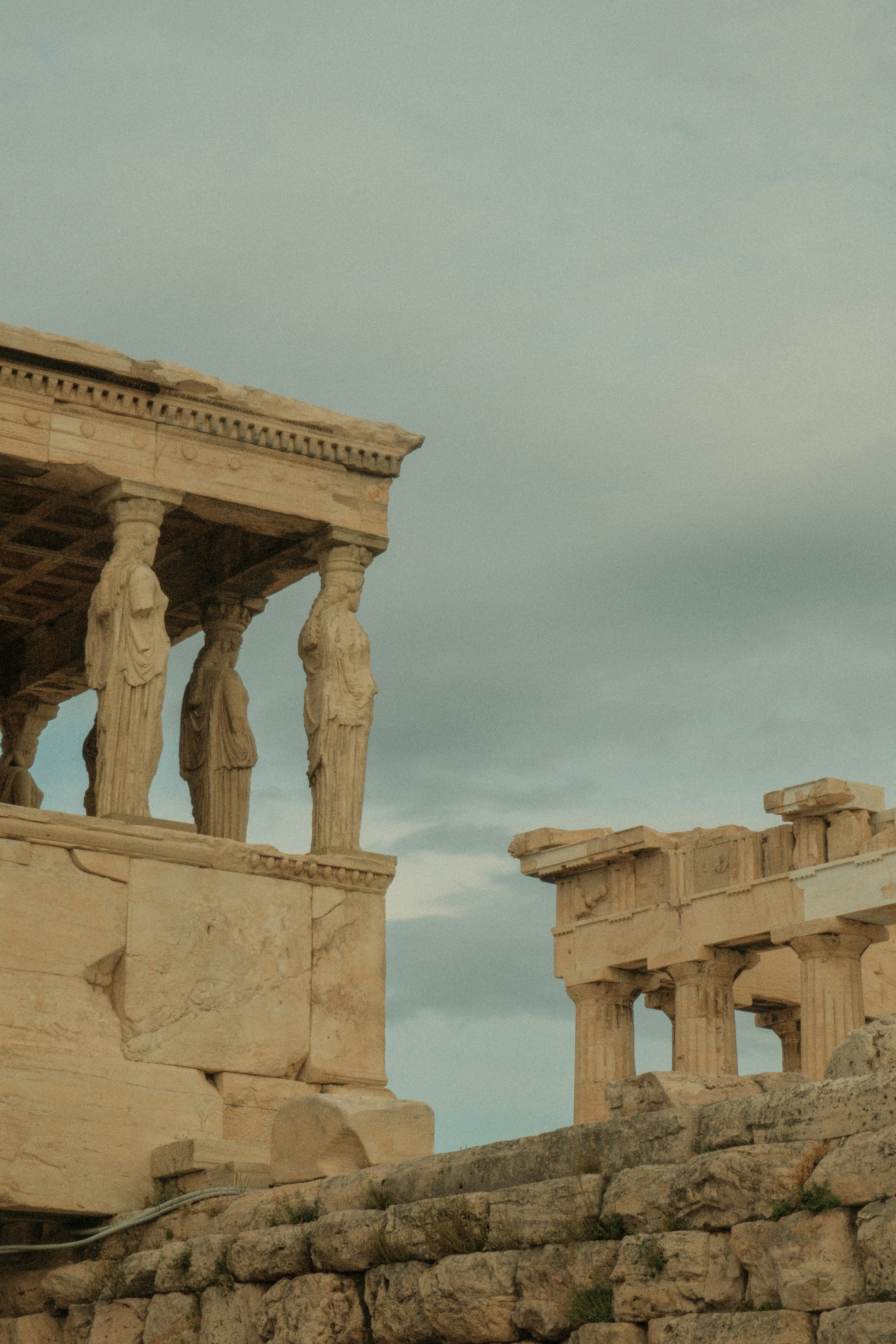 A bird flying over a stone structure with statues photo – Free Greece ...