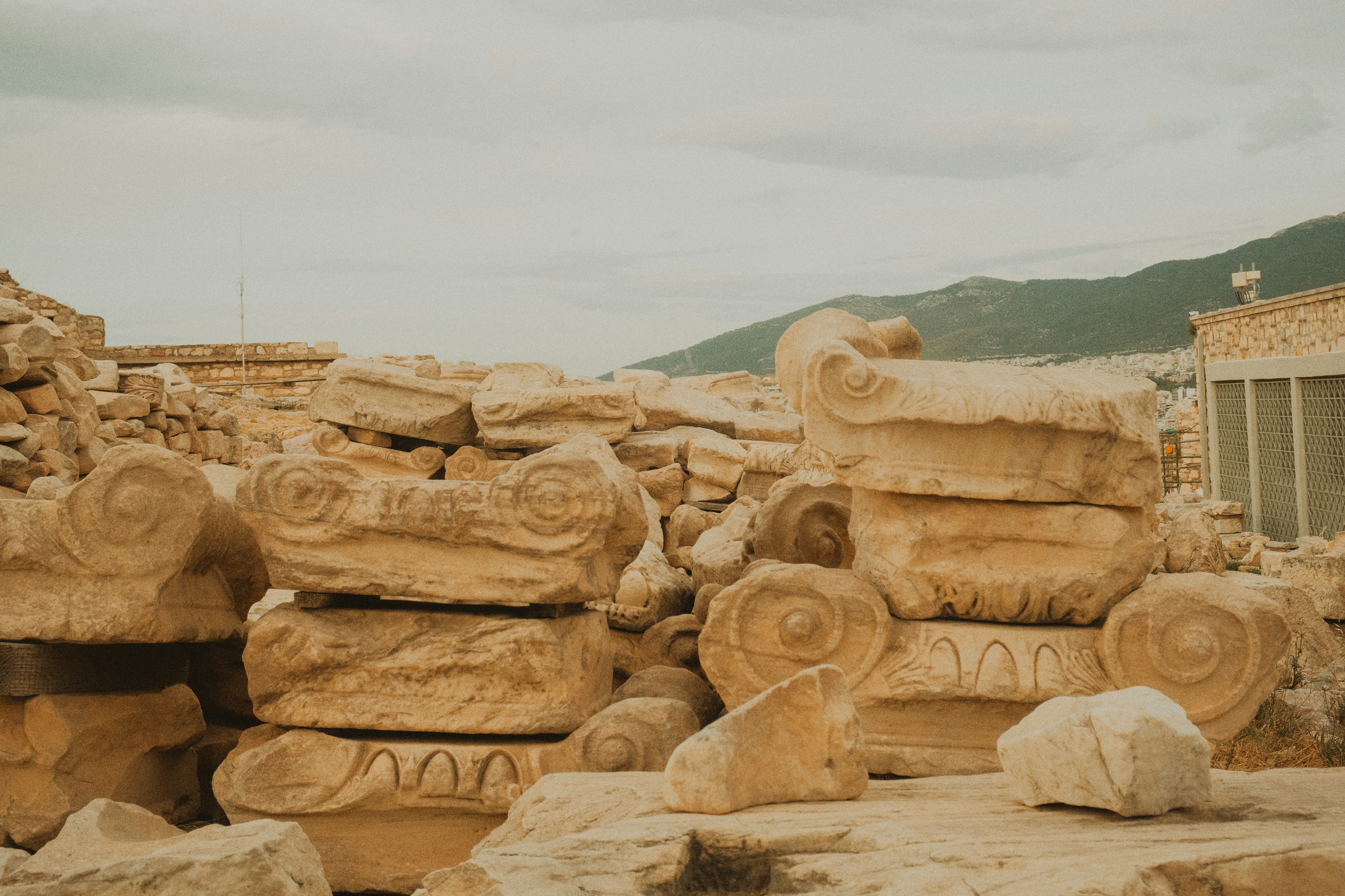 a large pile of stone sculptures sitting on top of a dirt field