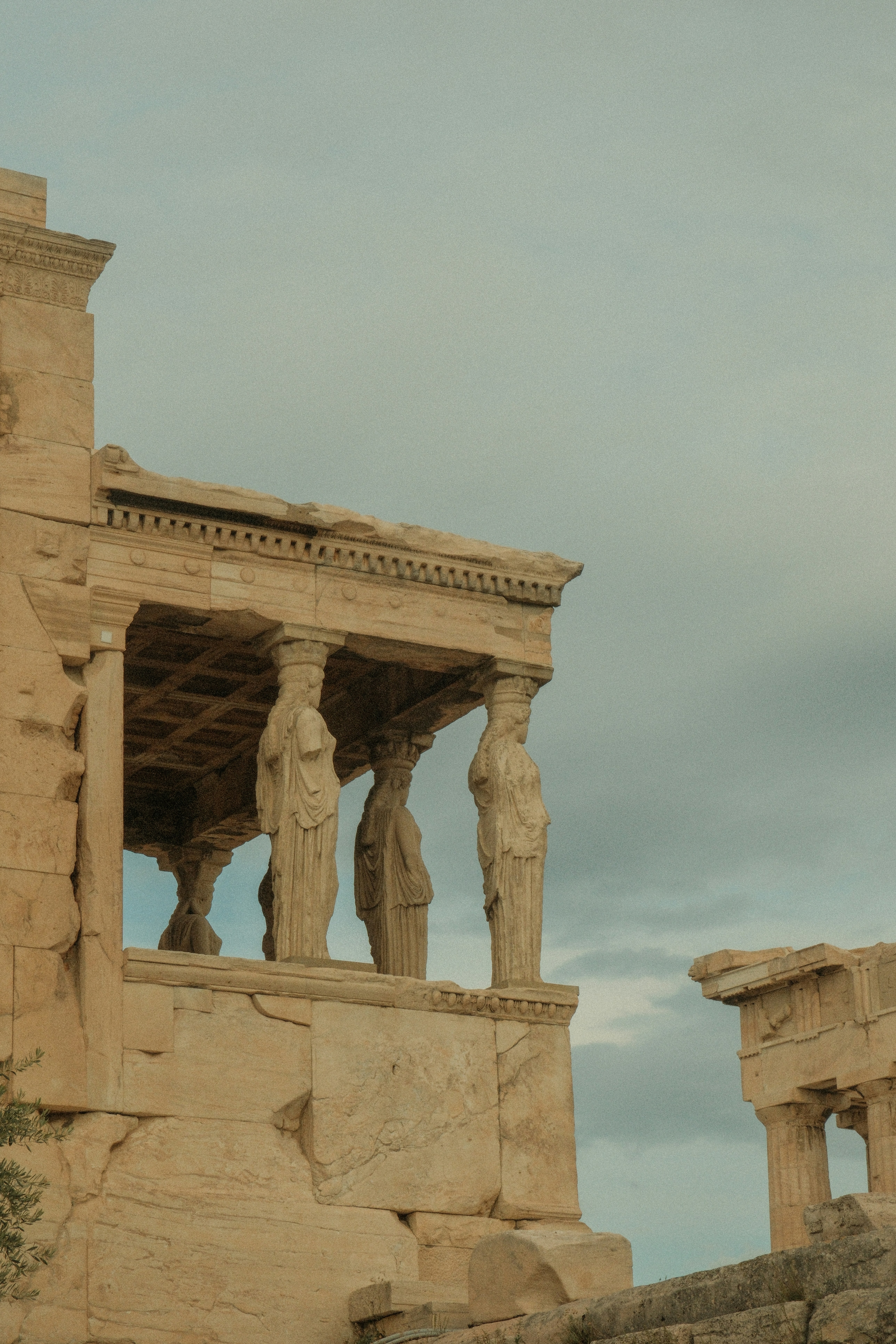 Carved Guardians on a Grecian Balcony under a Serene Sky