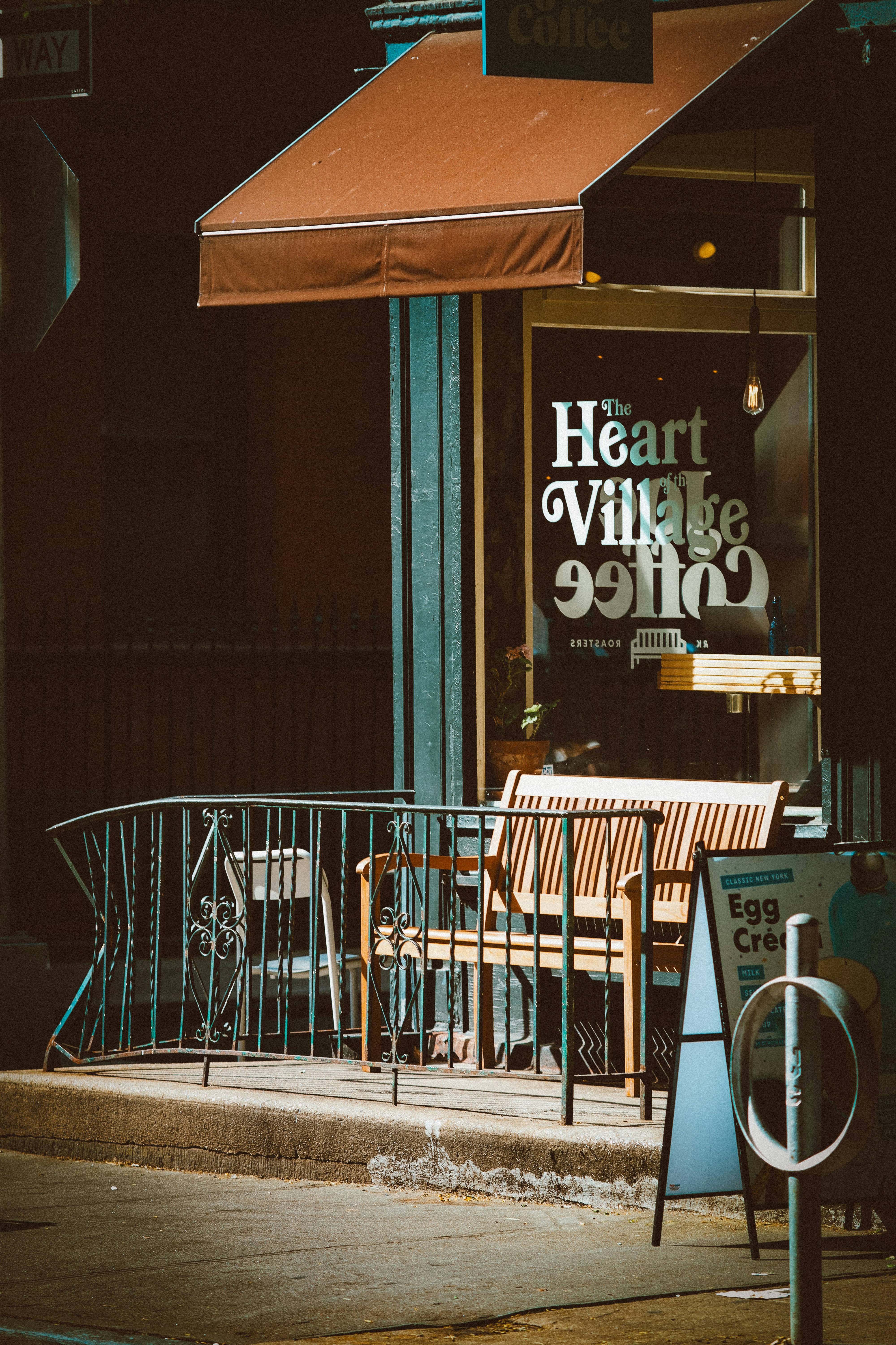 Dusk at The Heart Village Coffee: A Quiet Café Front Framed by Iron Railing