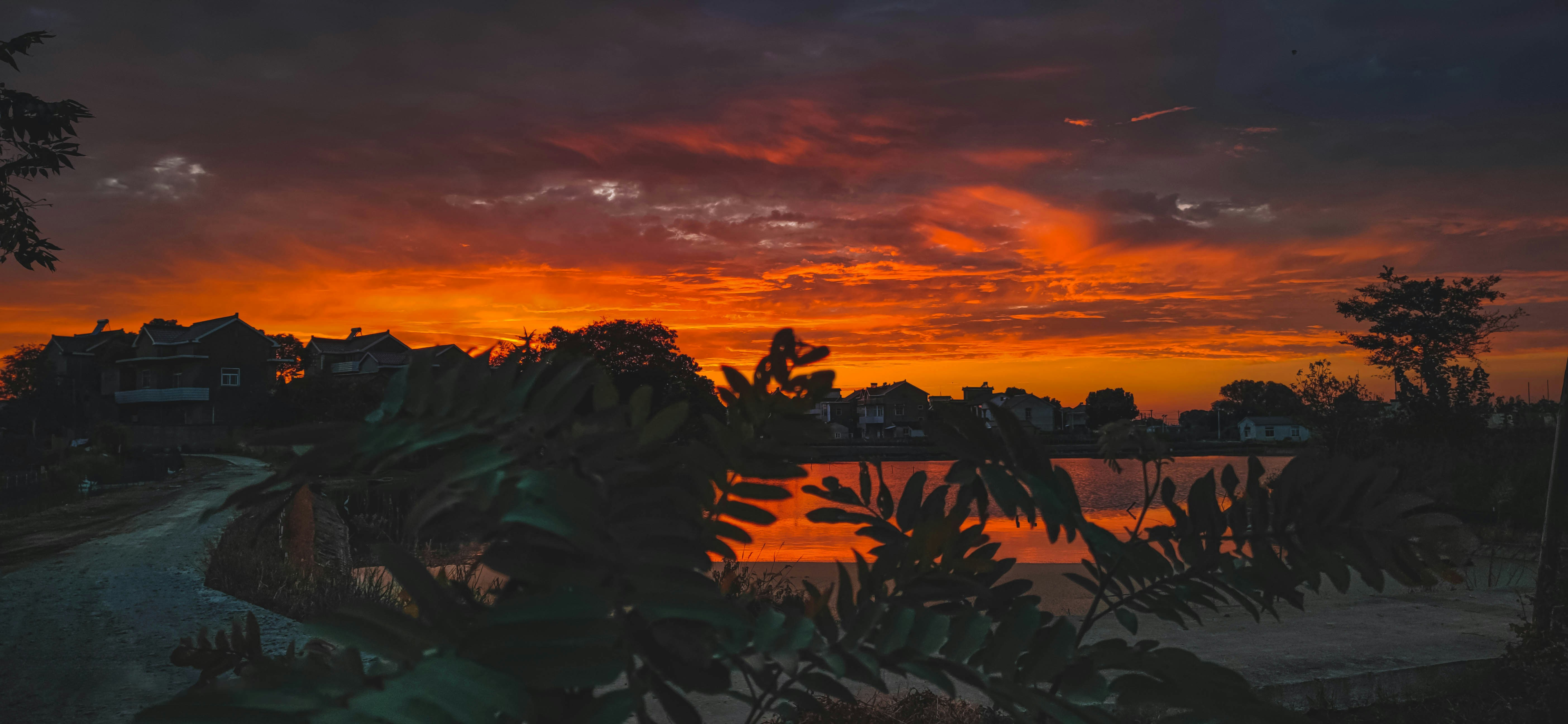 Fiery sky over a quiet lakeside village at dusk