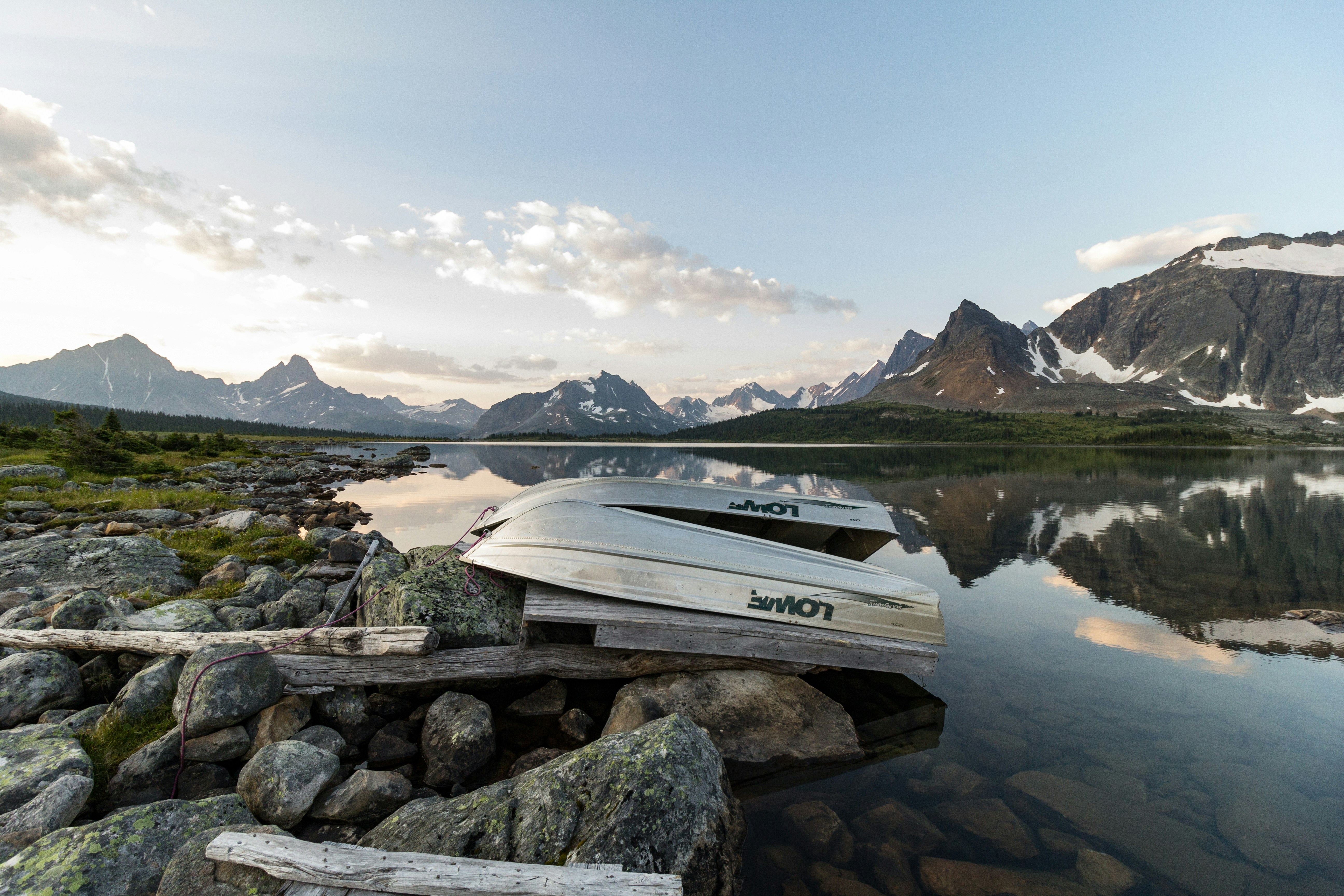 Folded Boats Rest on a Rocky Shore by Alpine Lake at Dusk