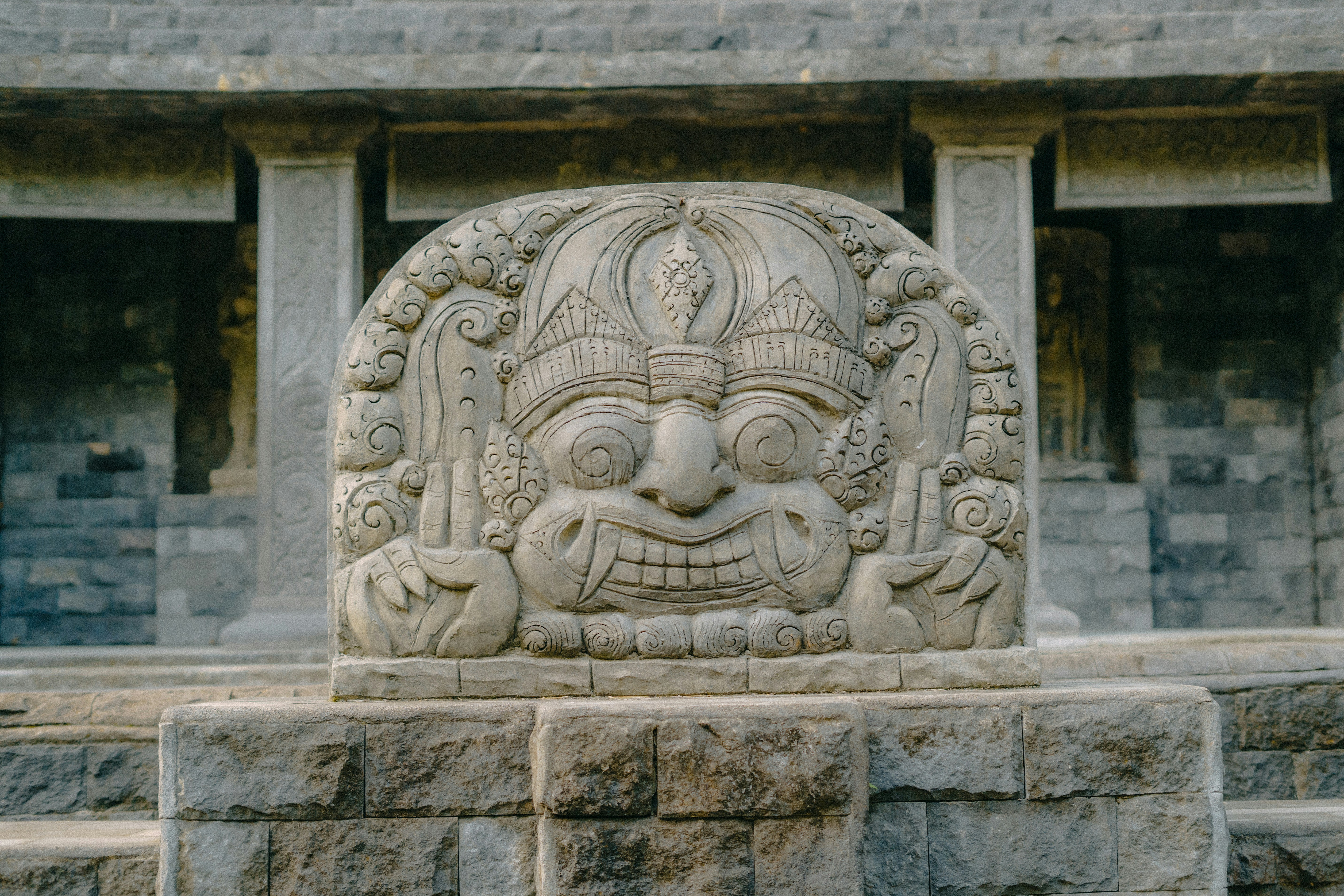 Stone Guardian Mask Emerges from Weathered Temple Steps