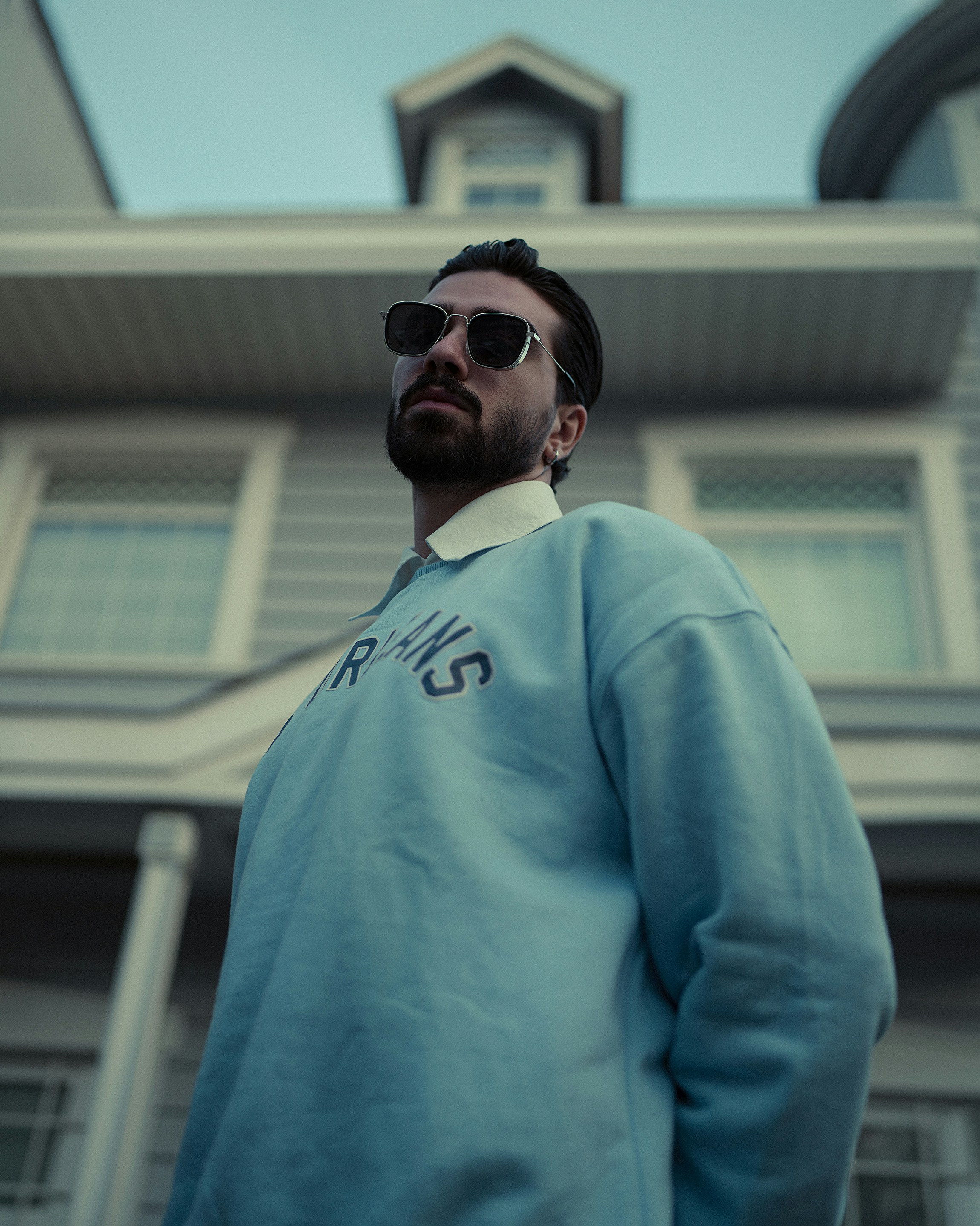 Blue-Sweater Portrait Under a Suburban Gable