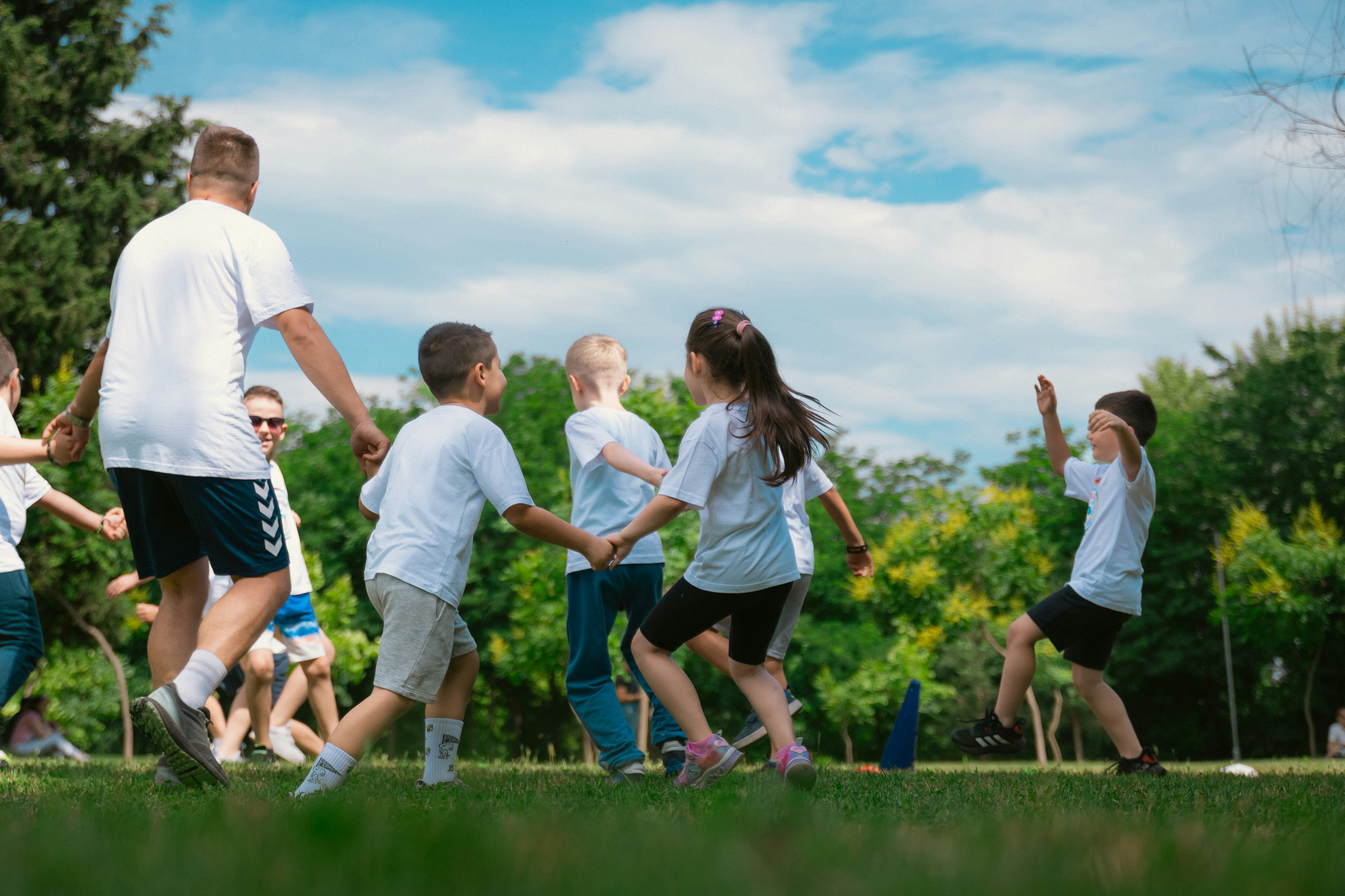 A group of children and adults playing a game of frisbee photo – Free ...