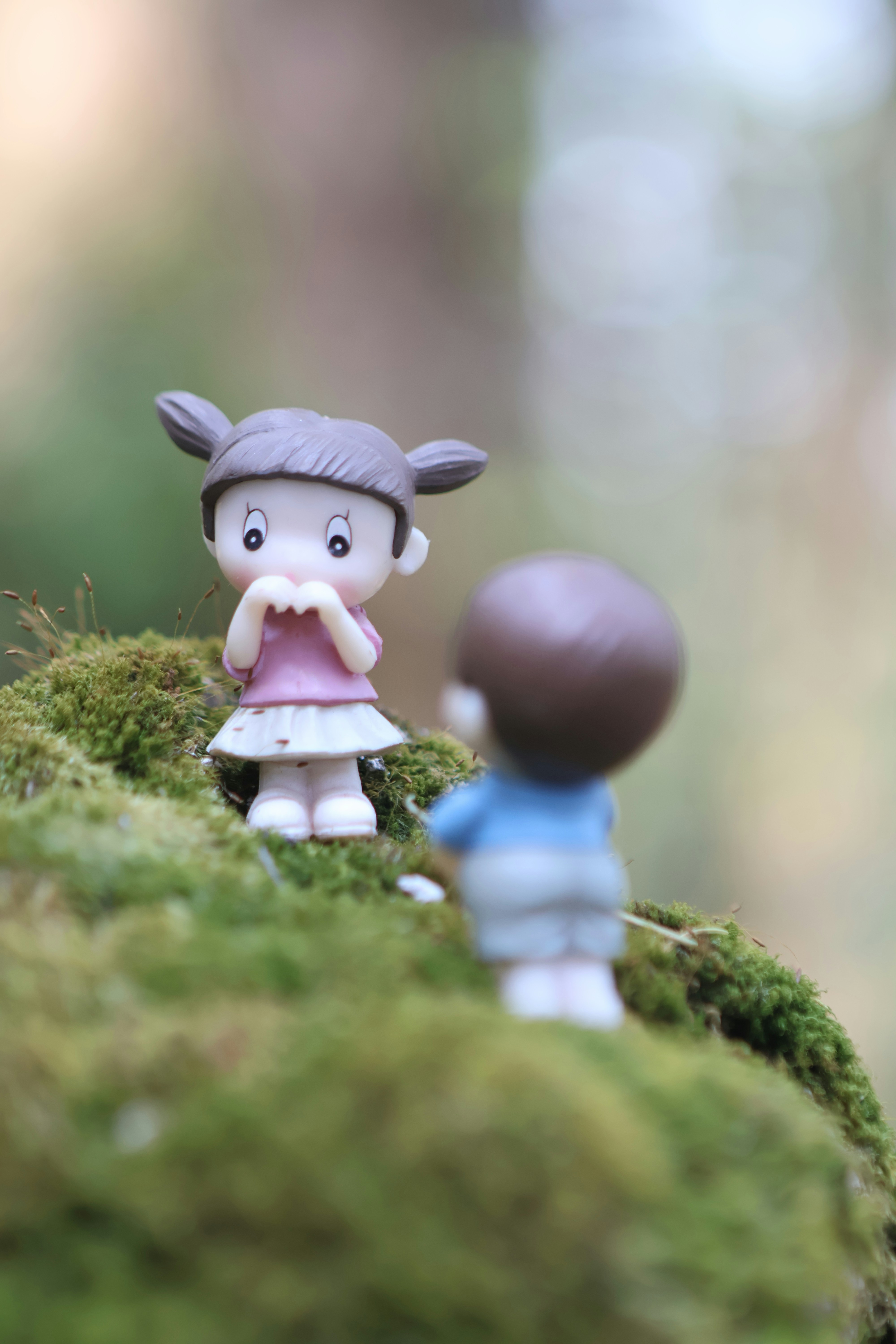 Mossbound Moment: Tiny Figures Share a Secret