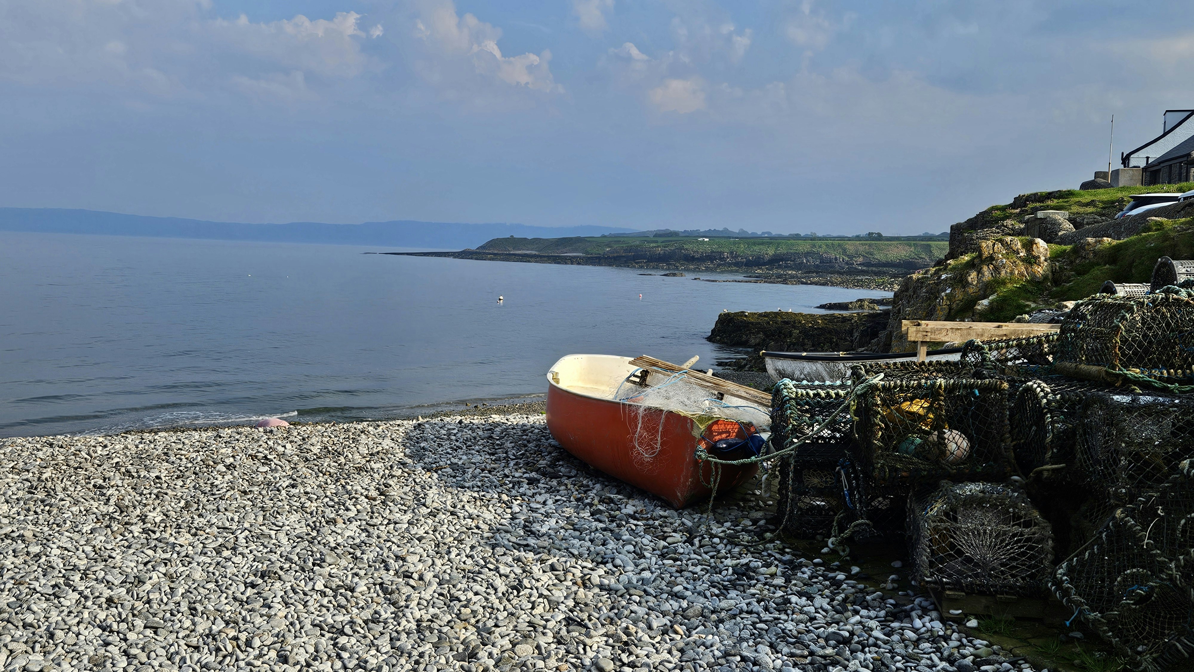 Orange Dinghy by Pebble Beach: Nets, Sea, and Quiet Horizon