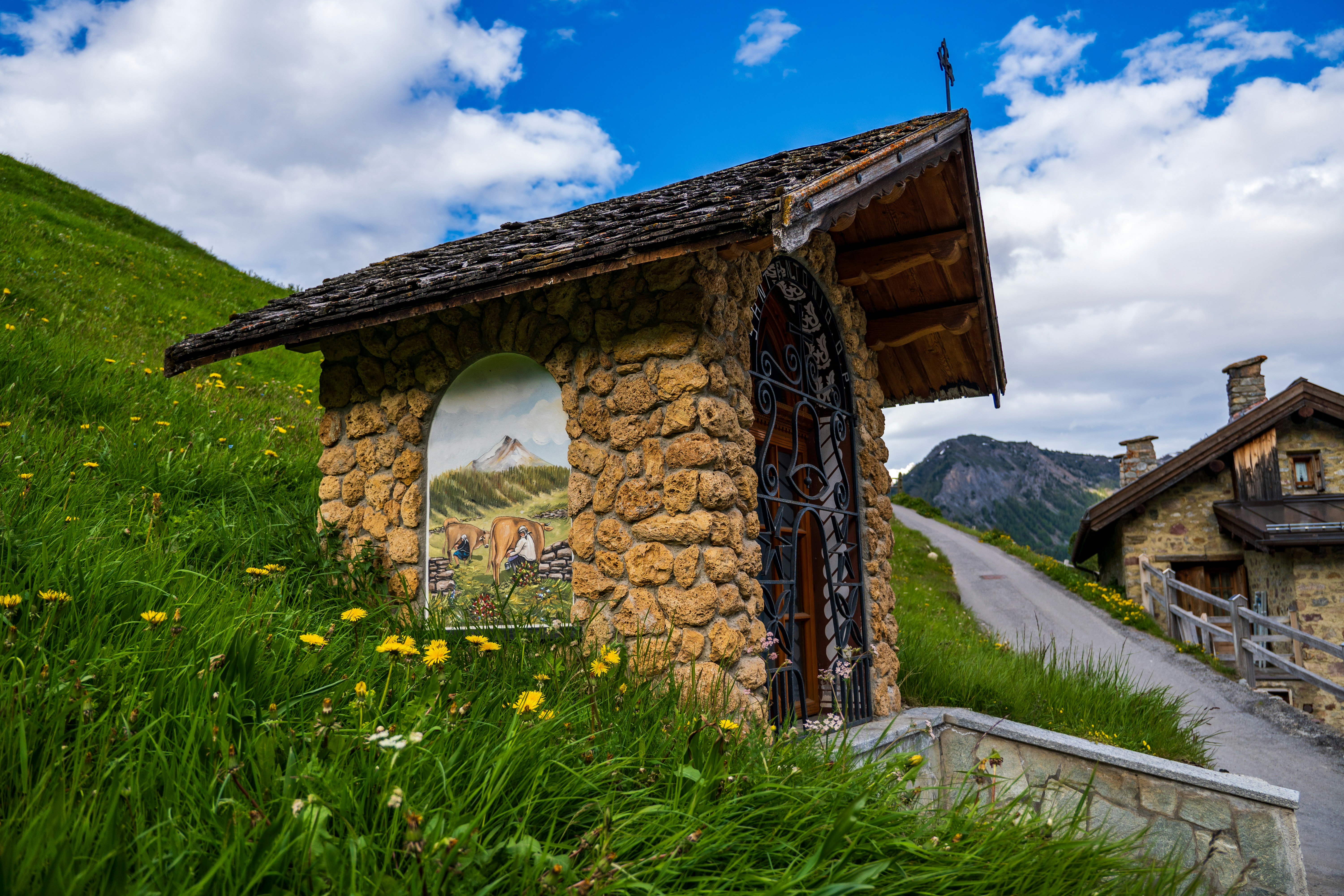 A small stone building with a painting on the side of it photo – Free ...