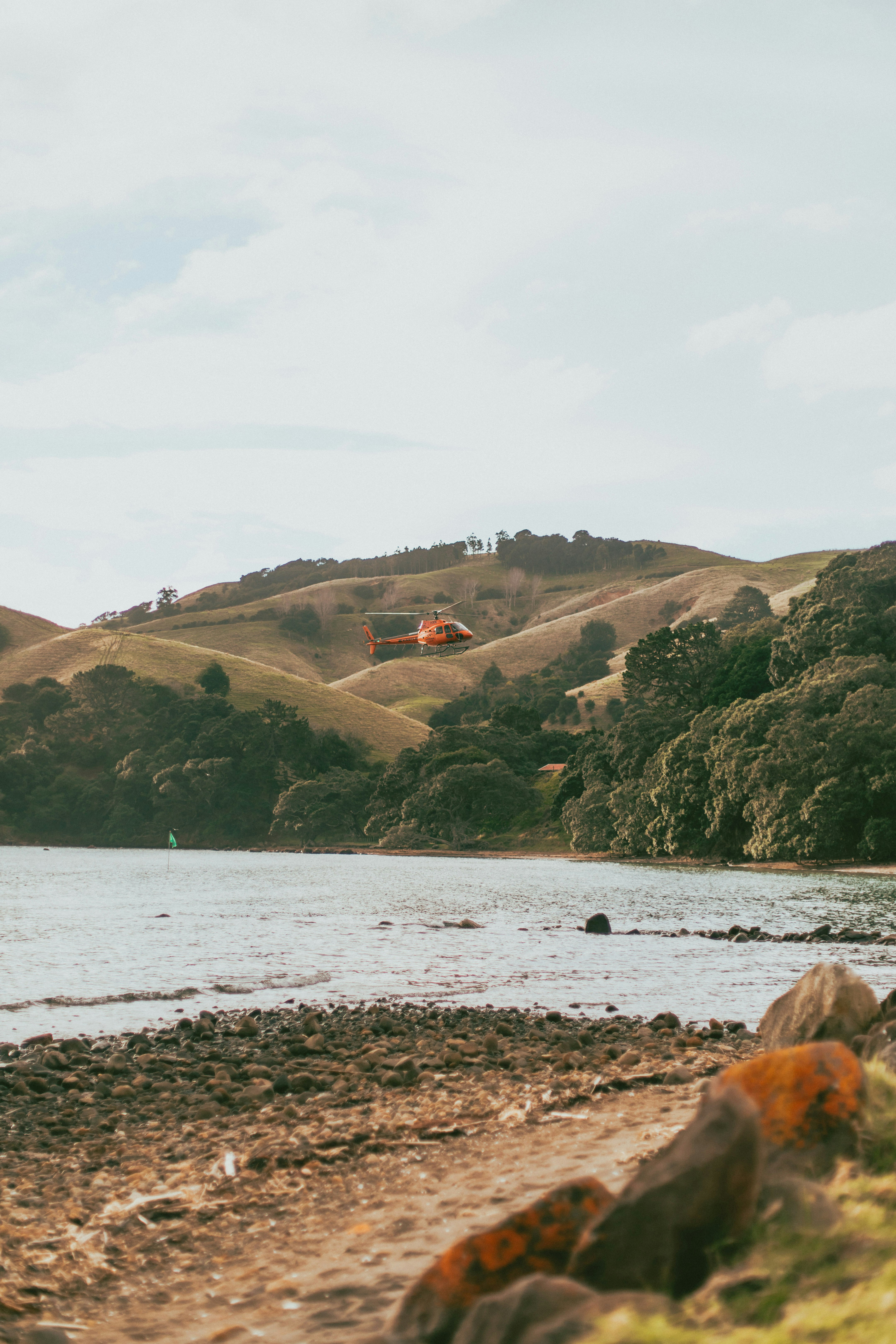 Orange Rescue Over Hills: A Helicopter Flew Above the Coastal Meadow