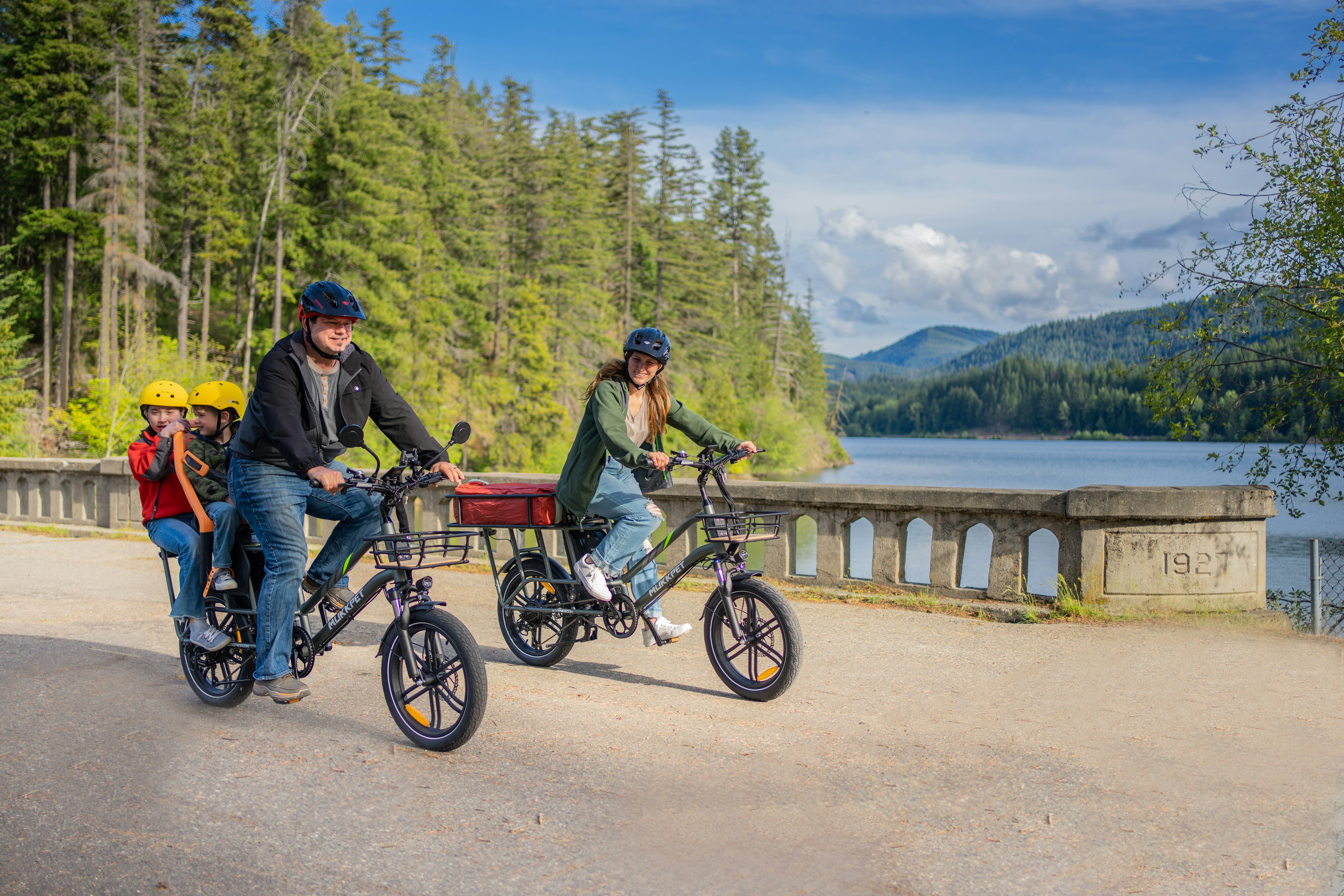 A couple of people riding bikes down a road photo – Free Bicycle Image ...