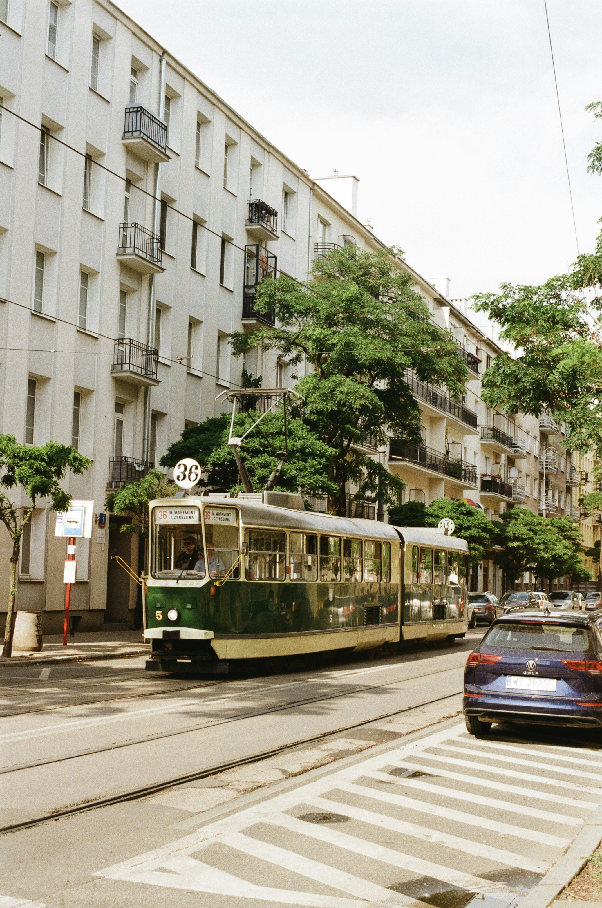 Un tramway vert descendant une rue à côté d’un grand immeuble photo ...