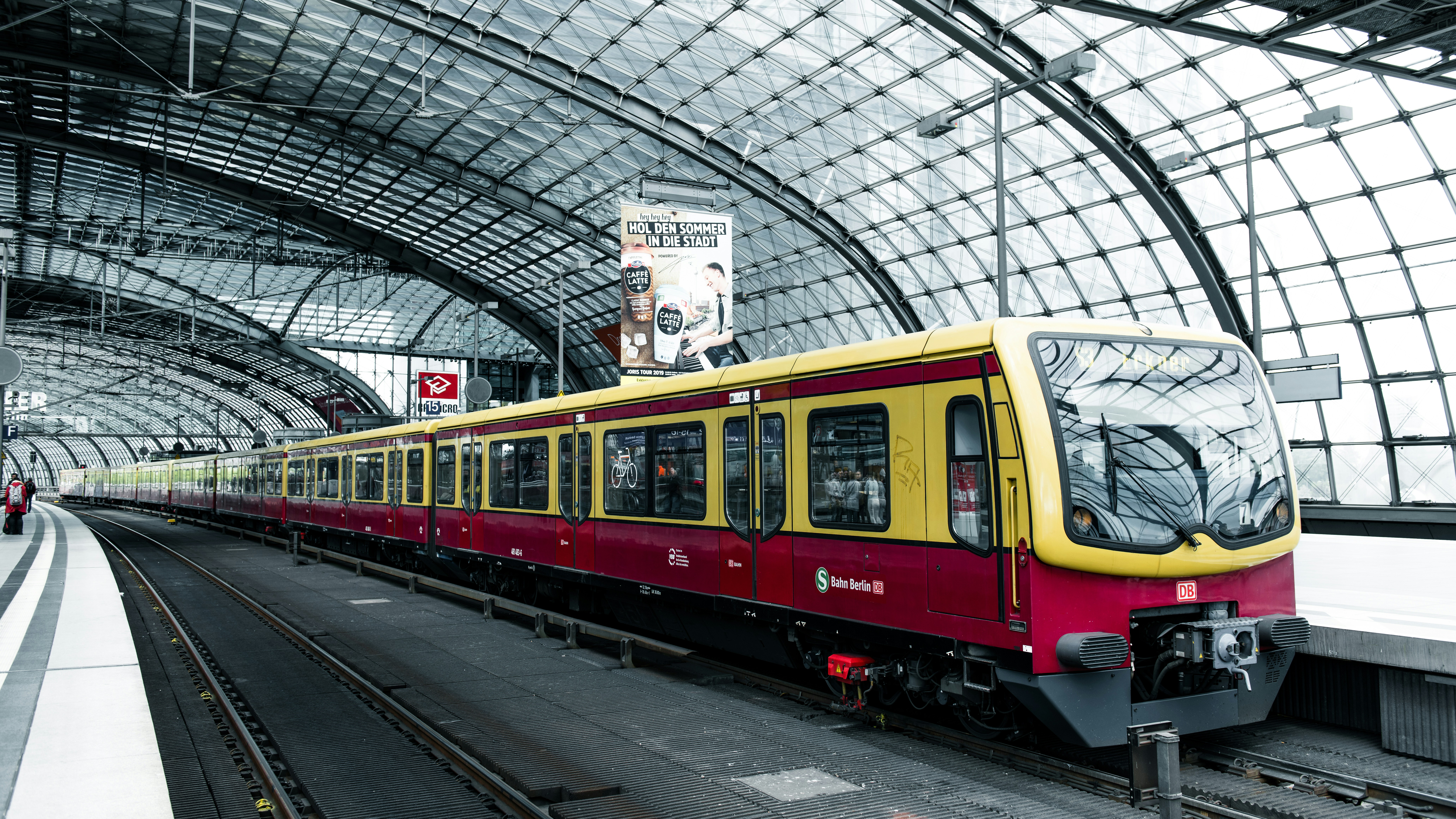 A red and yellow train pulling into a train station photo – Free Berlin ...