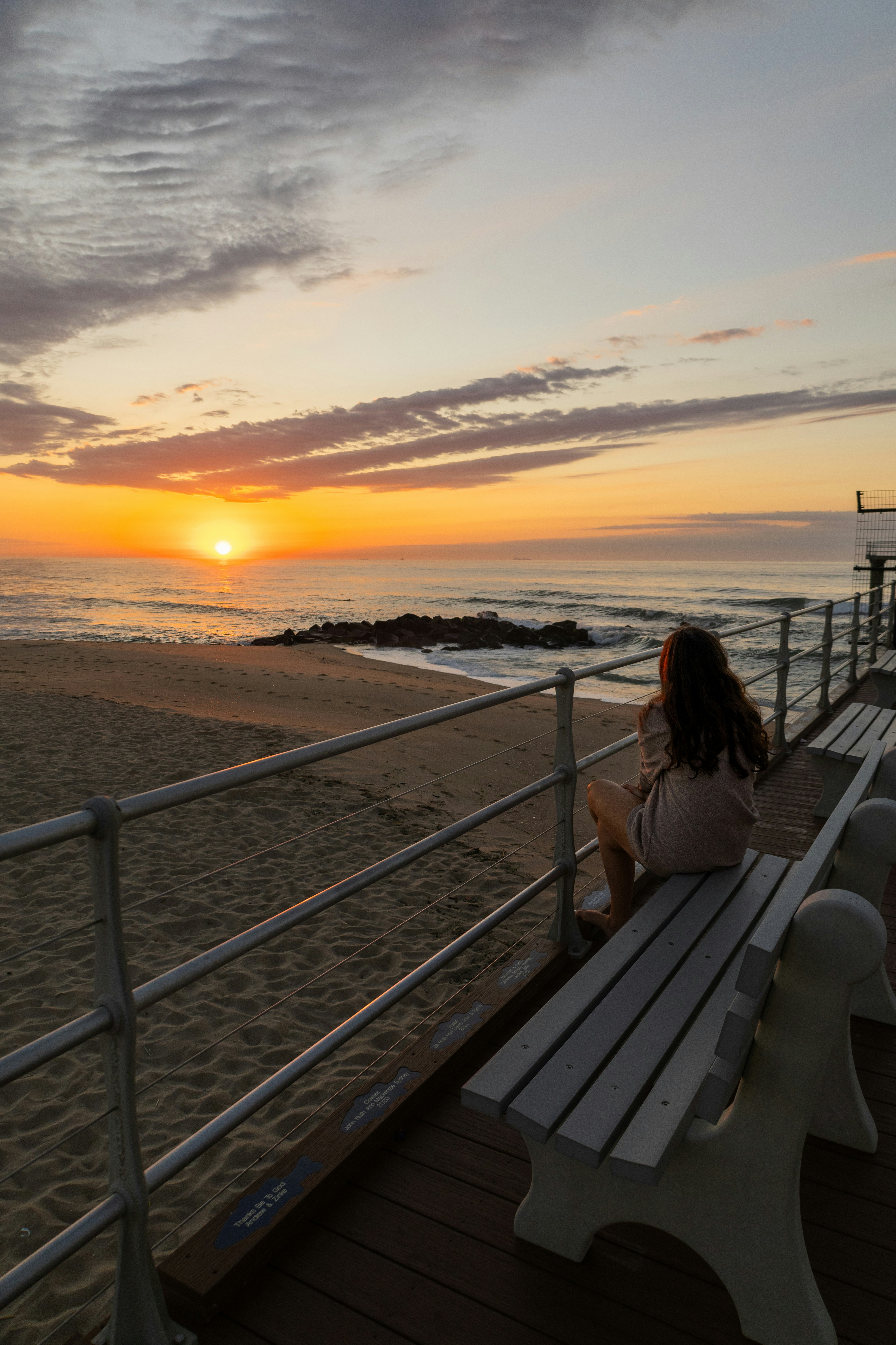 A woman sitting on a bench at the beach photo – Free Bradley beach ...