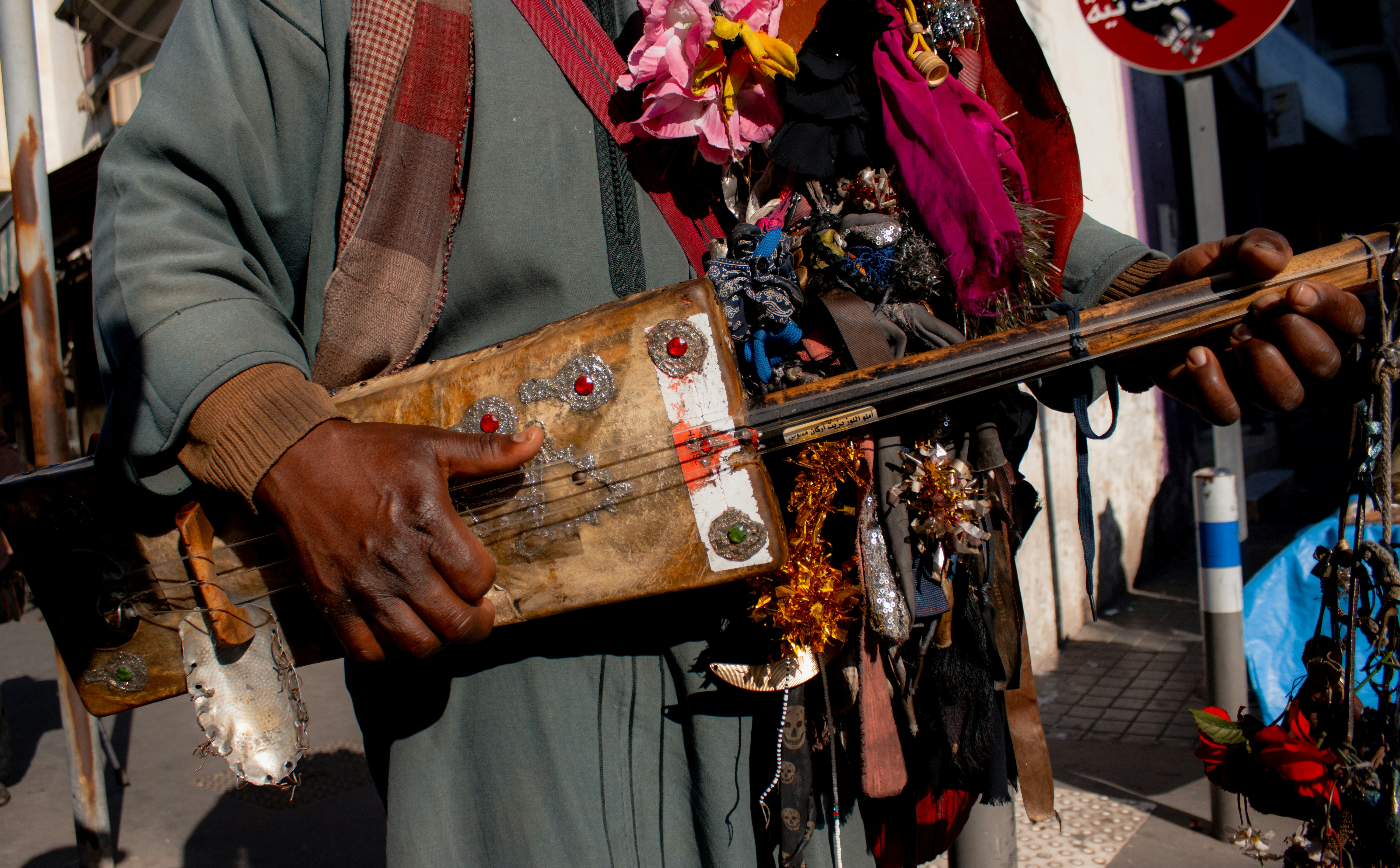 Bejeweled Strings Under Daylight: A Street Musician's Handcrafted Instrument