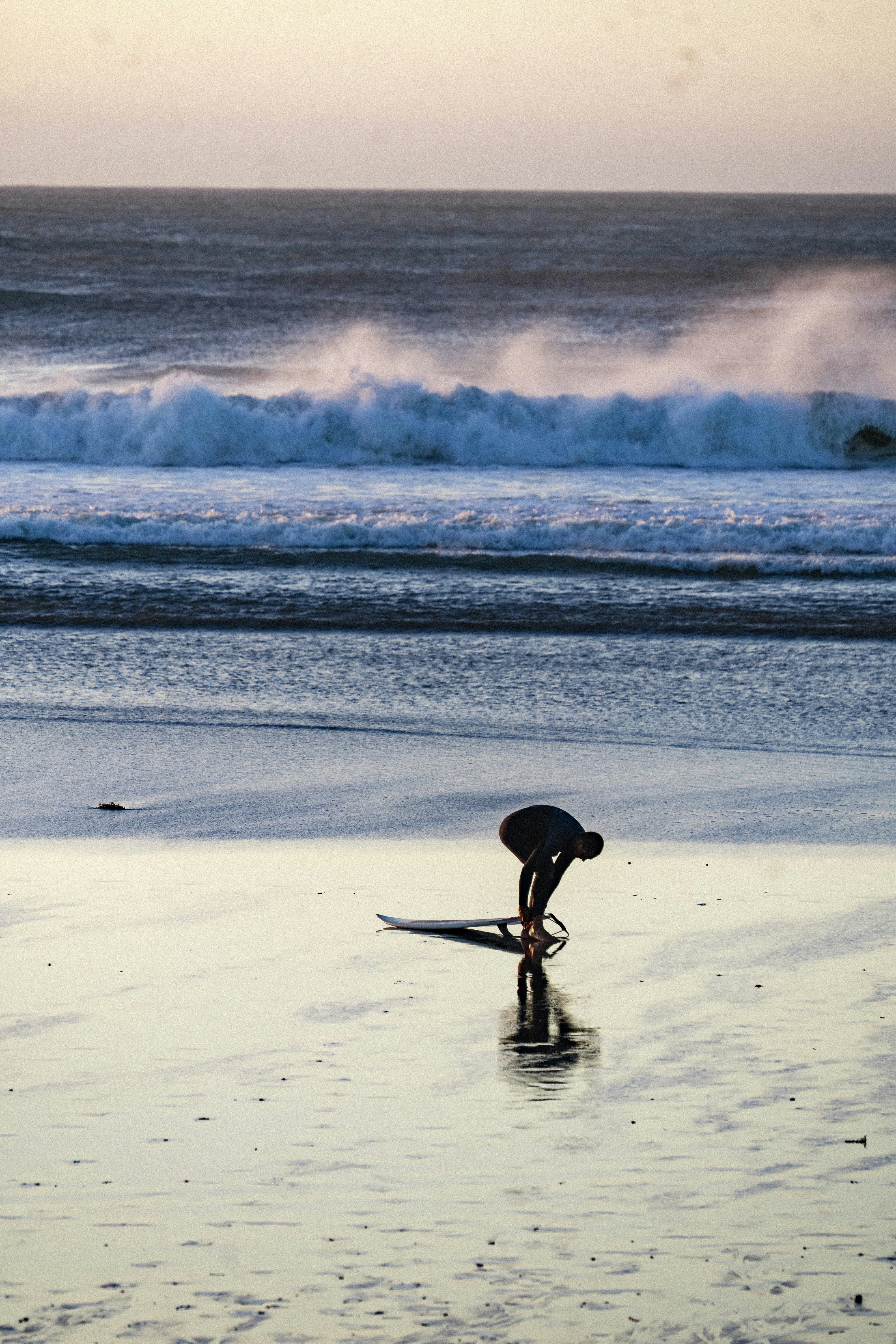 Rider in a Quiet Tide: Surfboard Silhouette at Dusk