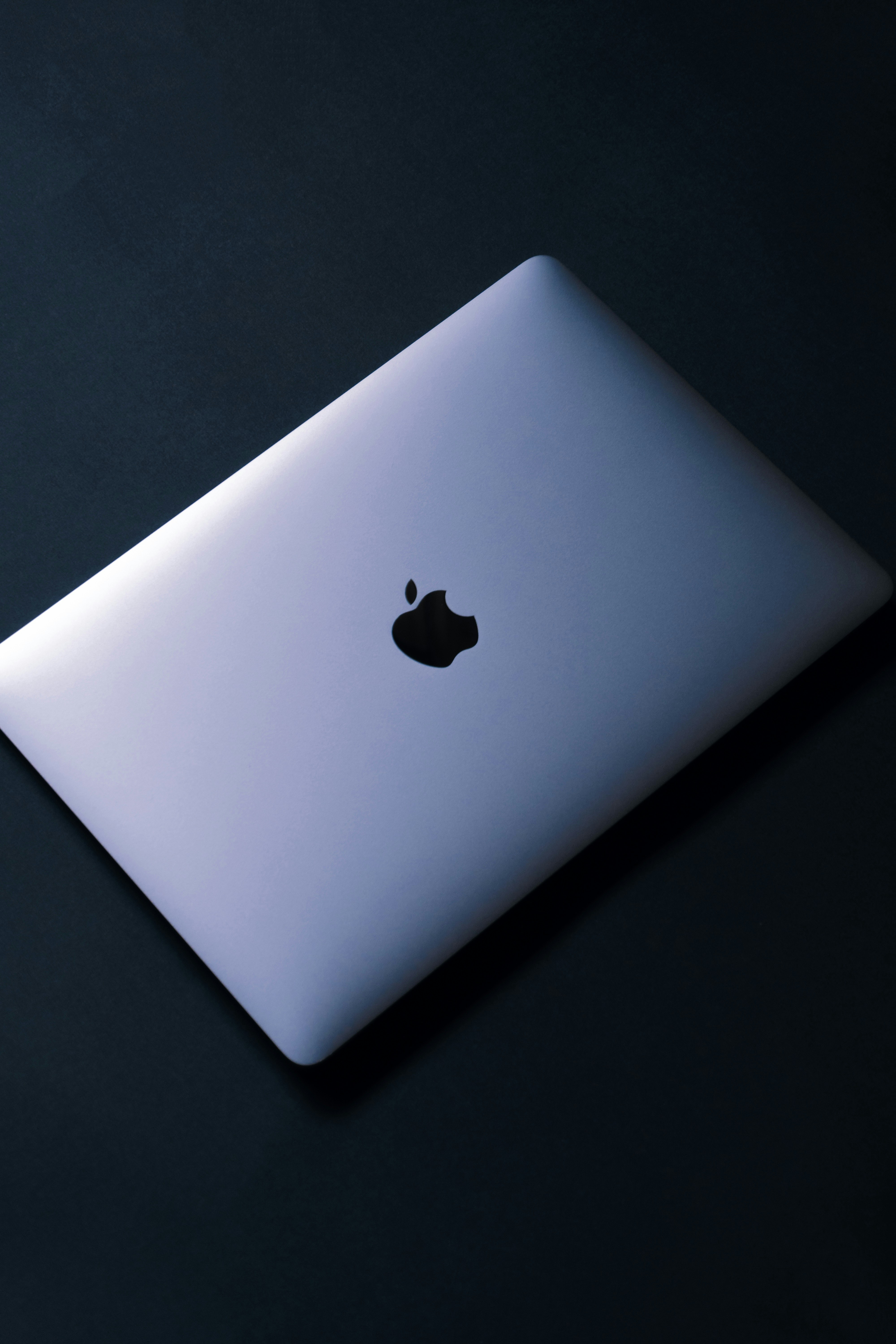 An apple laptop sitting on a black surface photo – Free Computer Image ...
