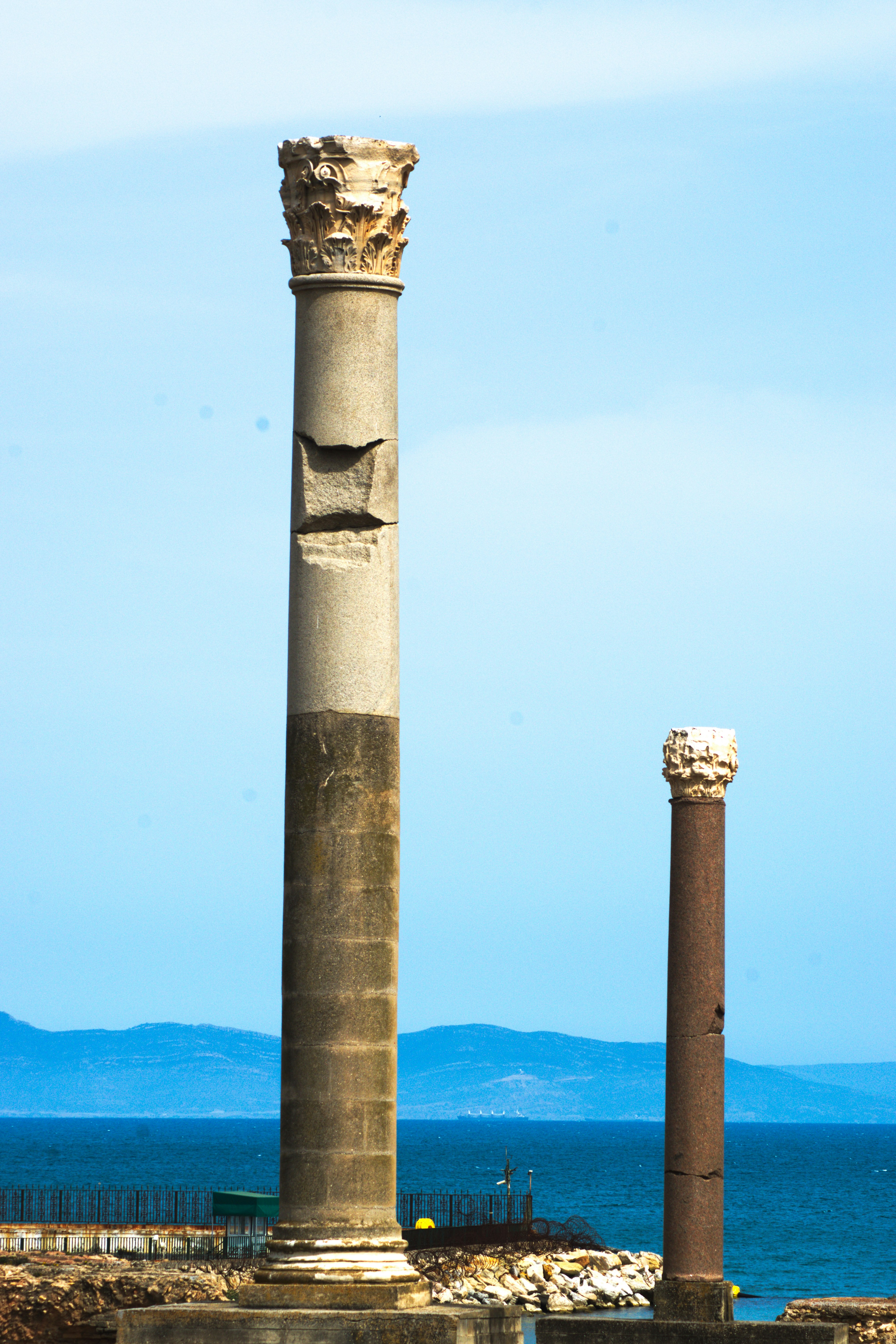 Coastal Column in Clear Blue: Weathered Stone at the Edge of the Sea