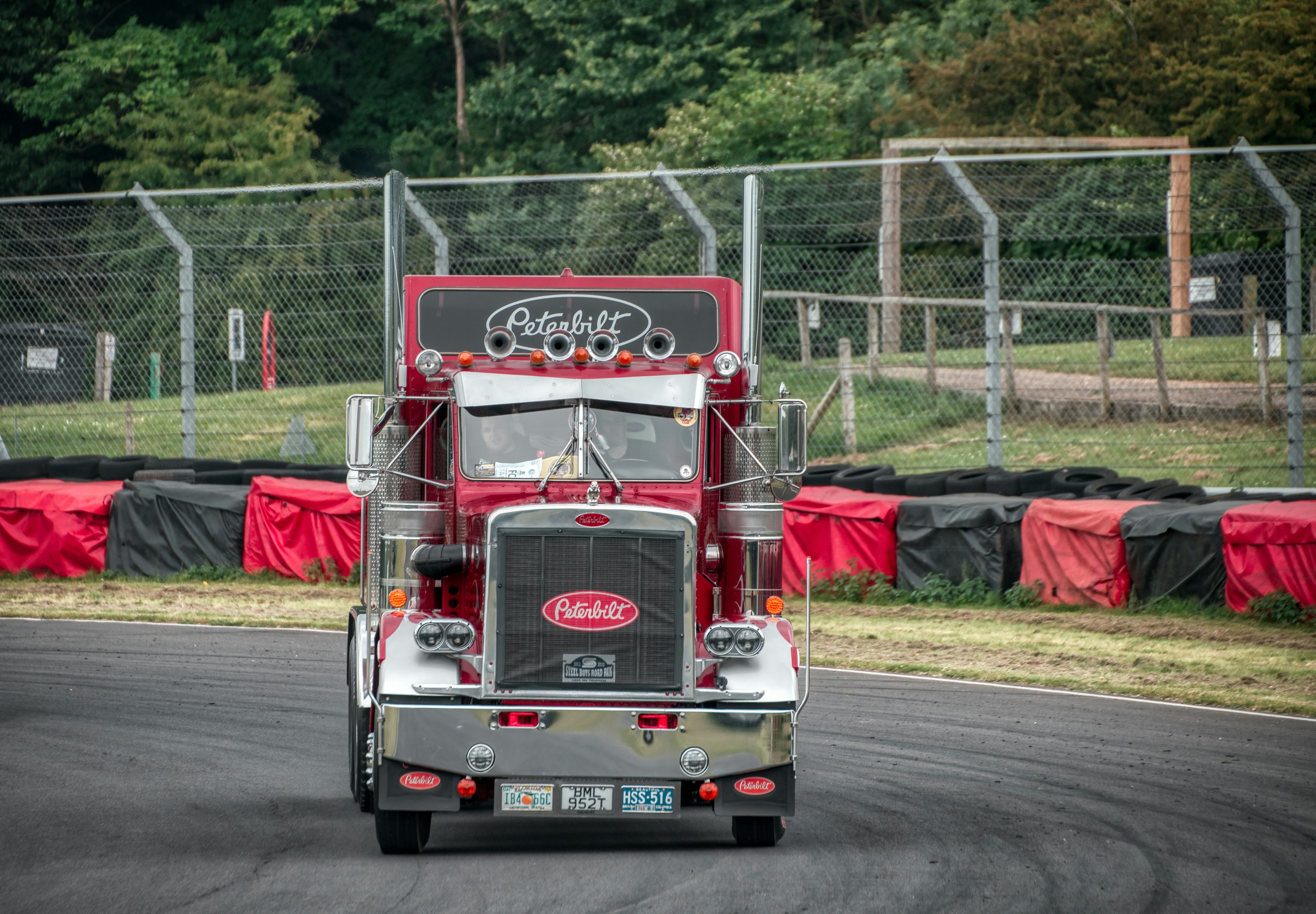 A red semi truck driving down a race track photo – Free Truck Image on ...