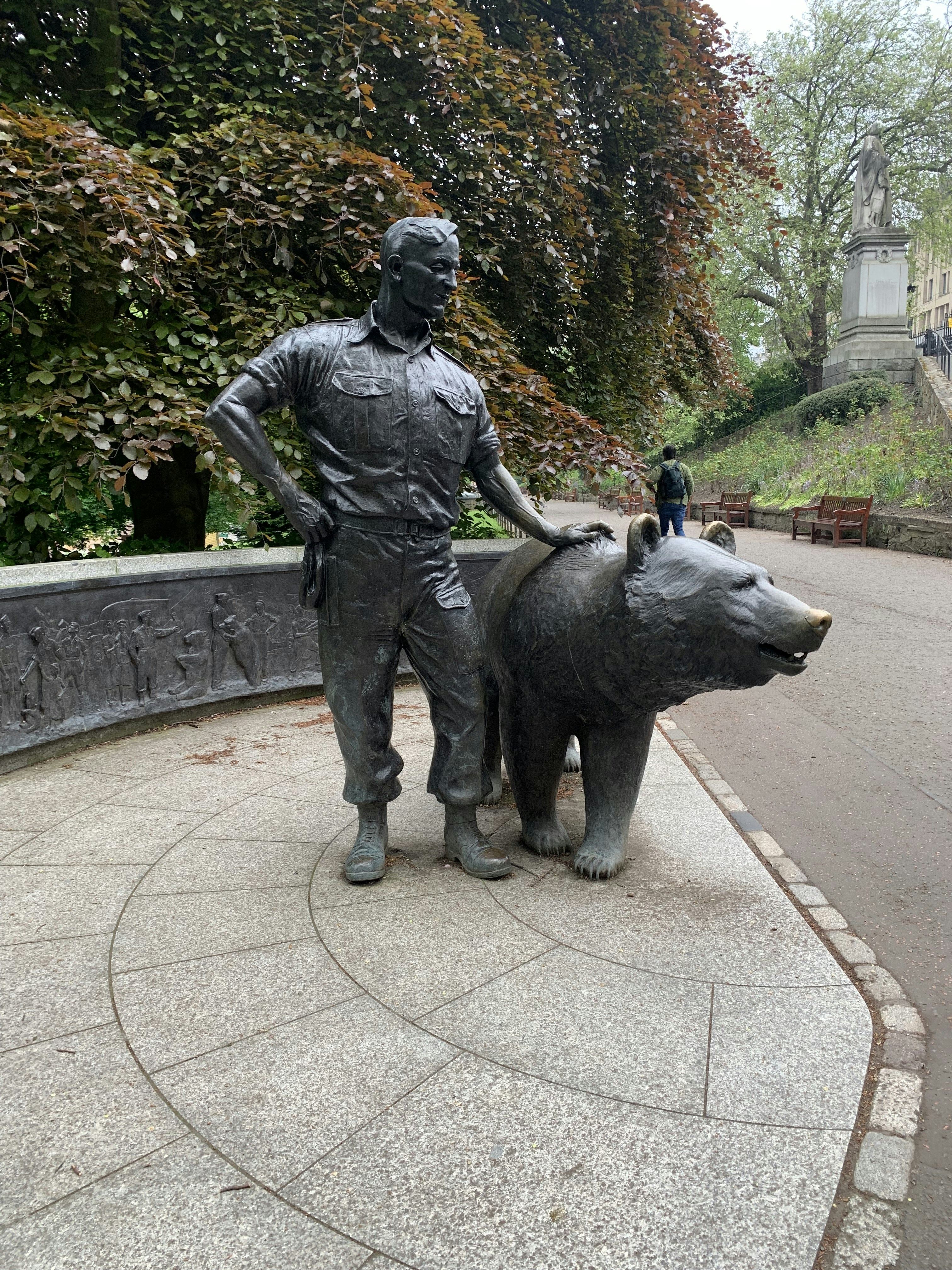 Bronze Sentinel and Bear: A Park Statue Duo by the Path