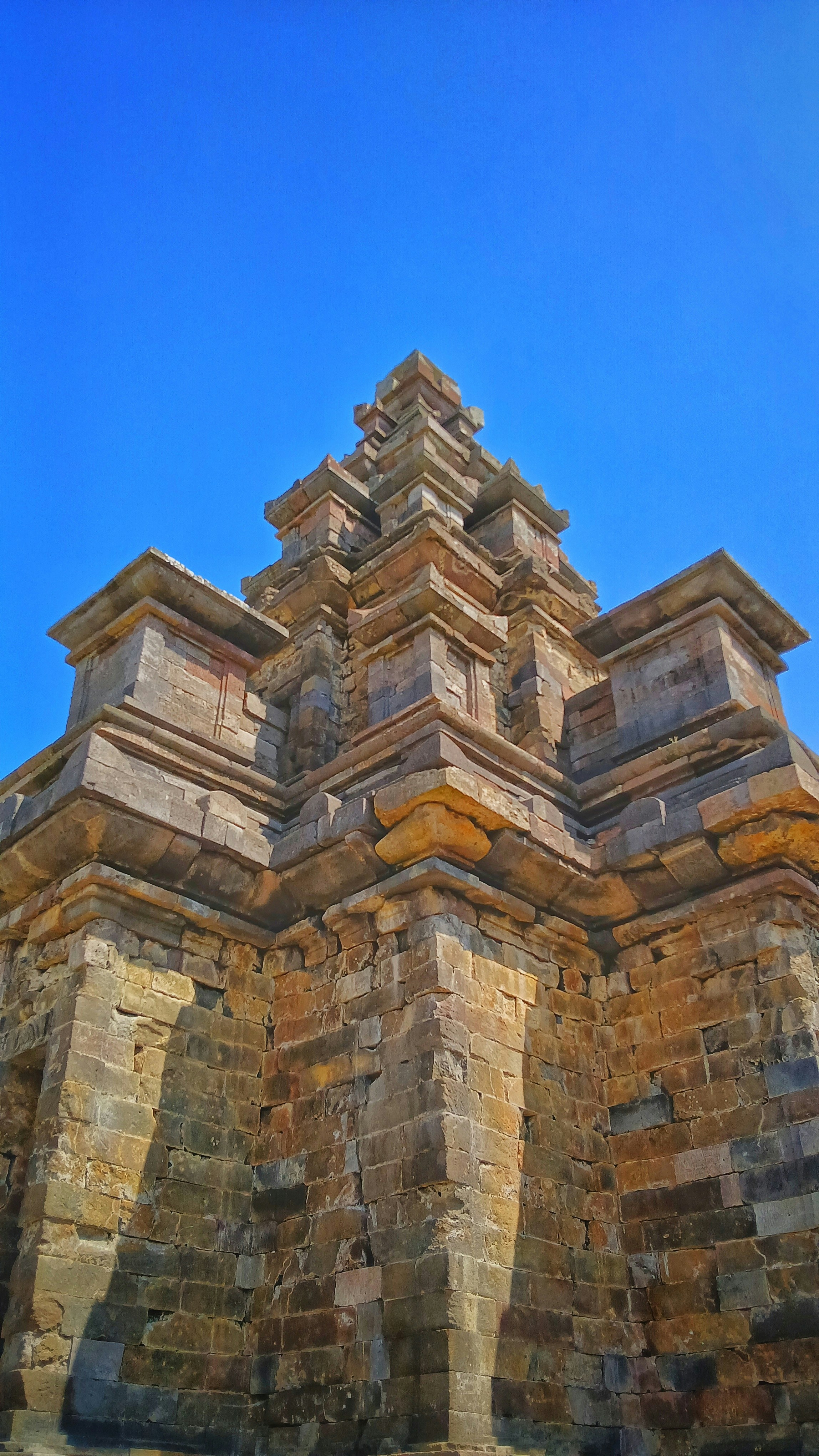 a very tall brick building with a clock on it's side