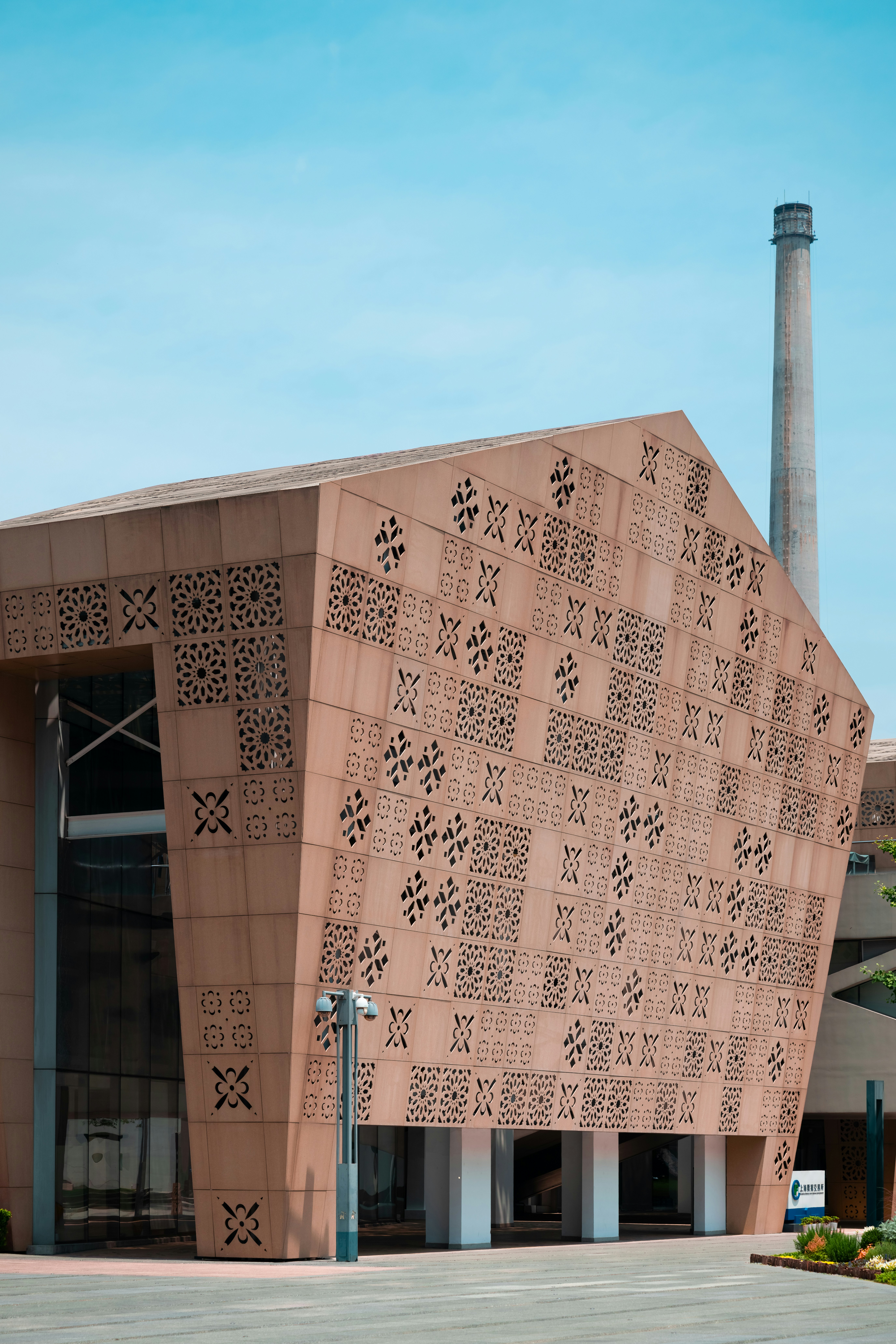 Bronze Lace: The Geometry of Perforated Panels Against a Clear Sky
