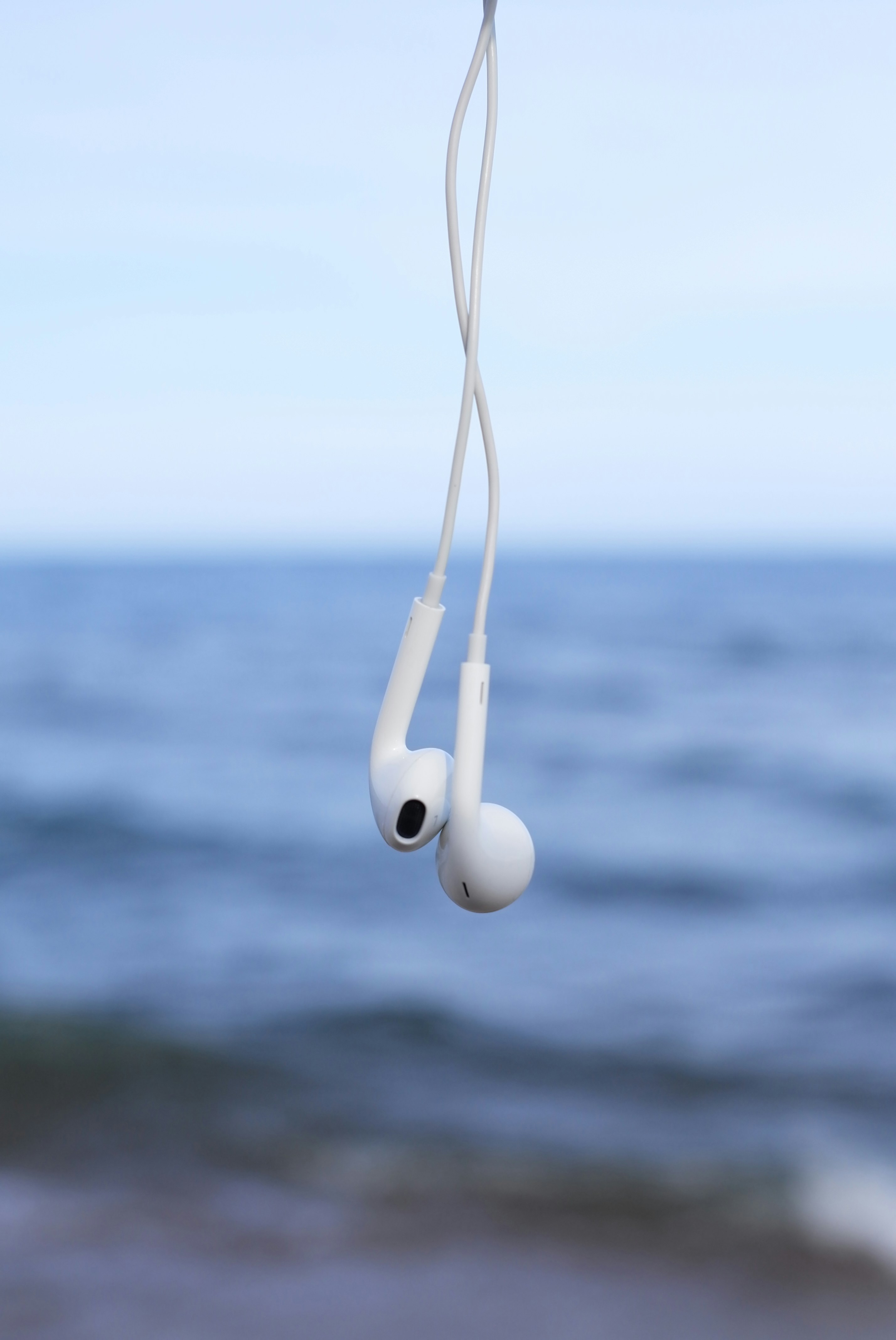 A pair of ear buds hanging from a string photo – Free Blue Image on ...