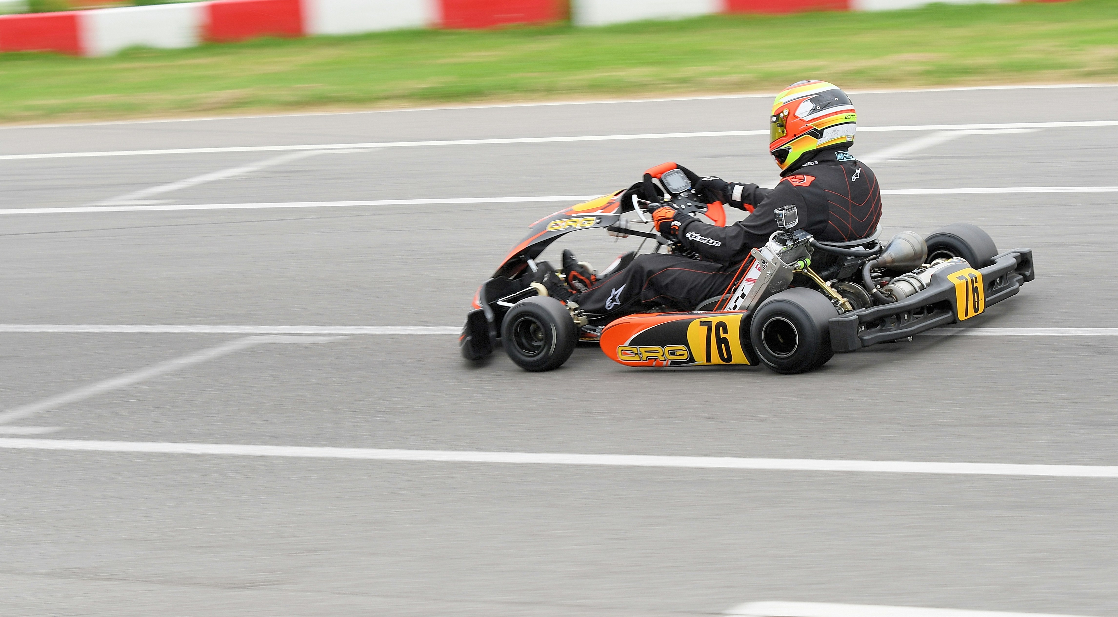 Two people racing a go kart on a race track photo – Free Car Image on ...
