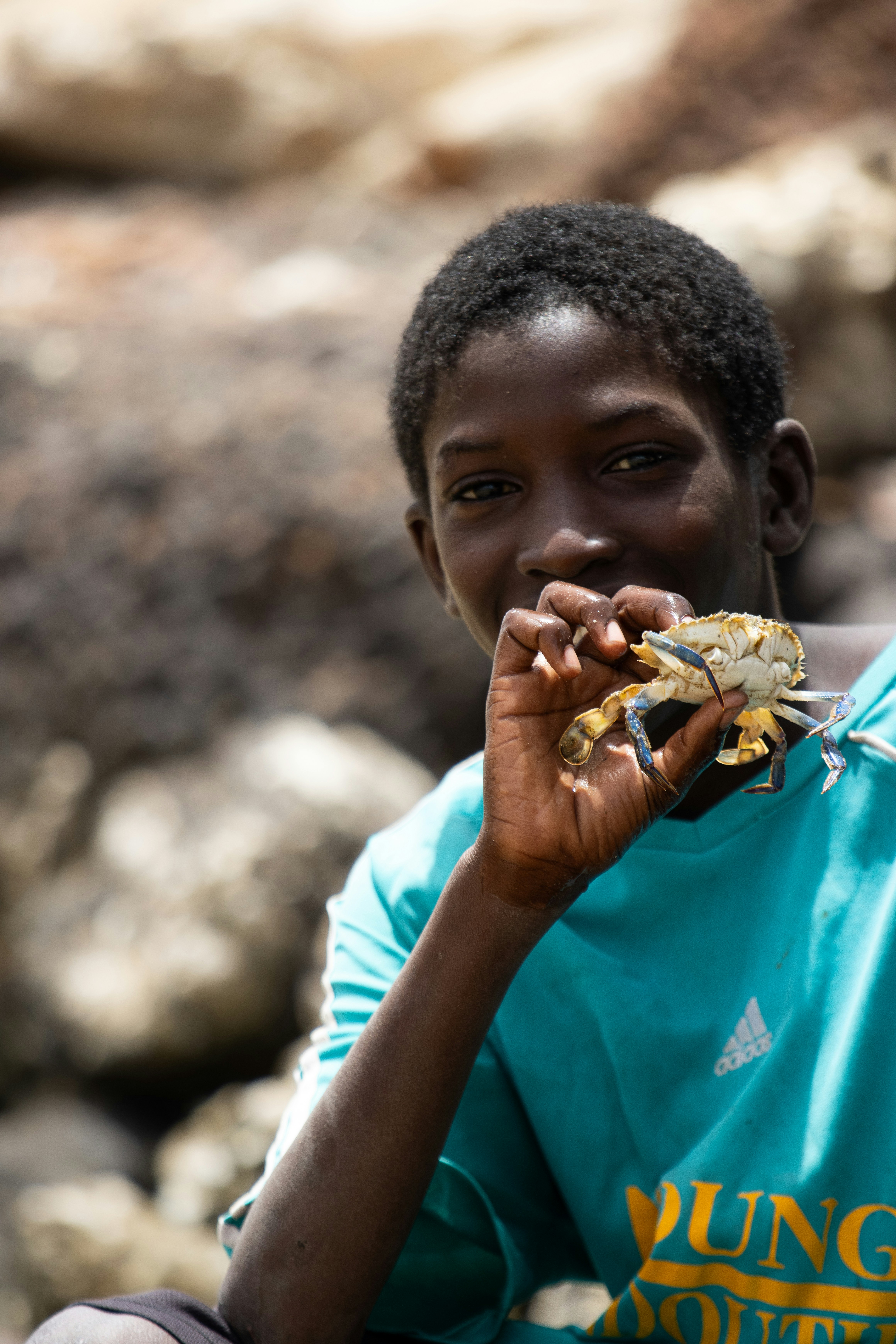 A young boy eating a lizard on a rock photo – Free Boy Image on Unsplash