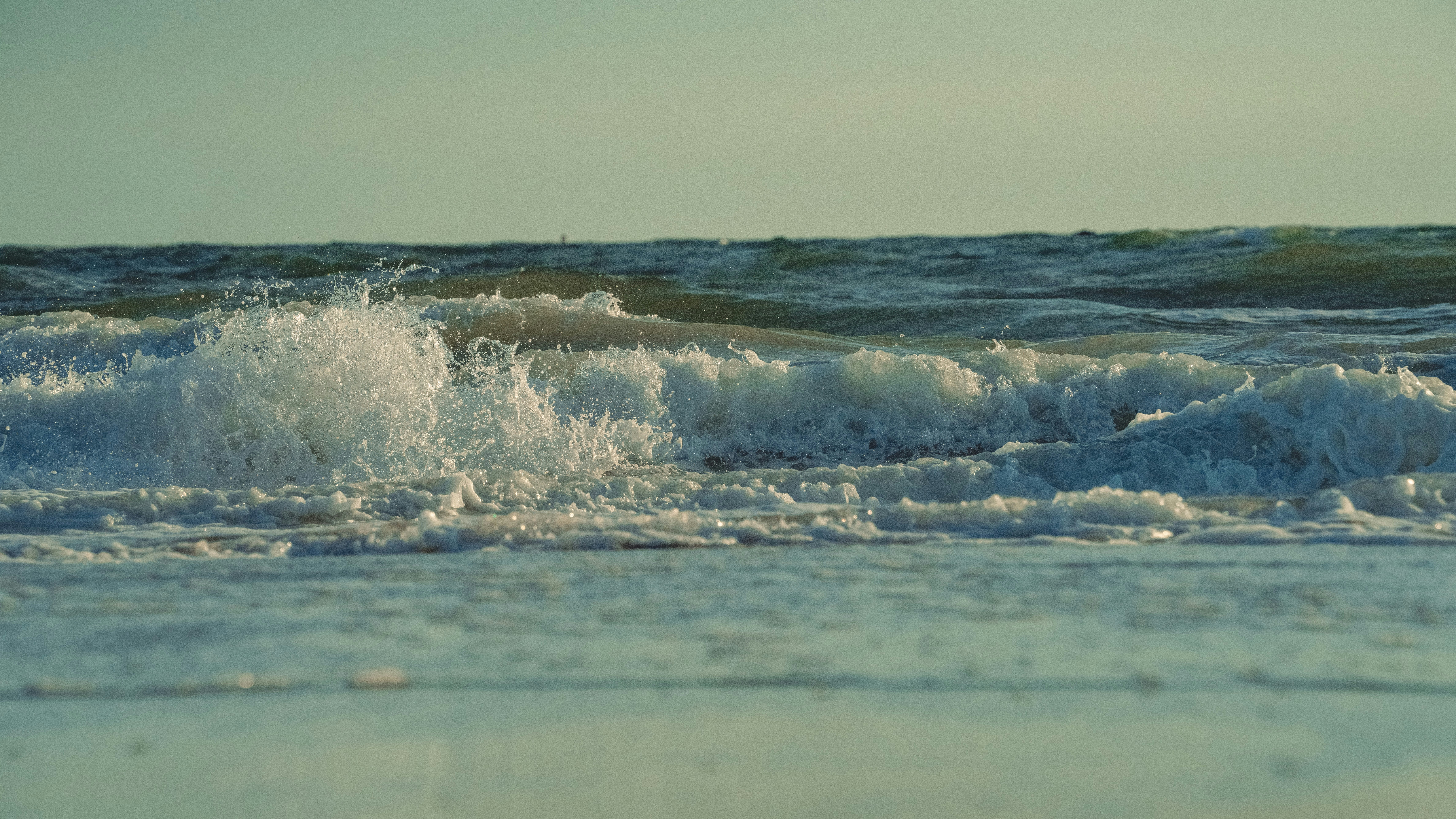 Una ola rompiendo en la orilla de una playa foto – Imagen de Santa ...