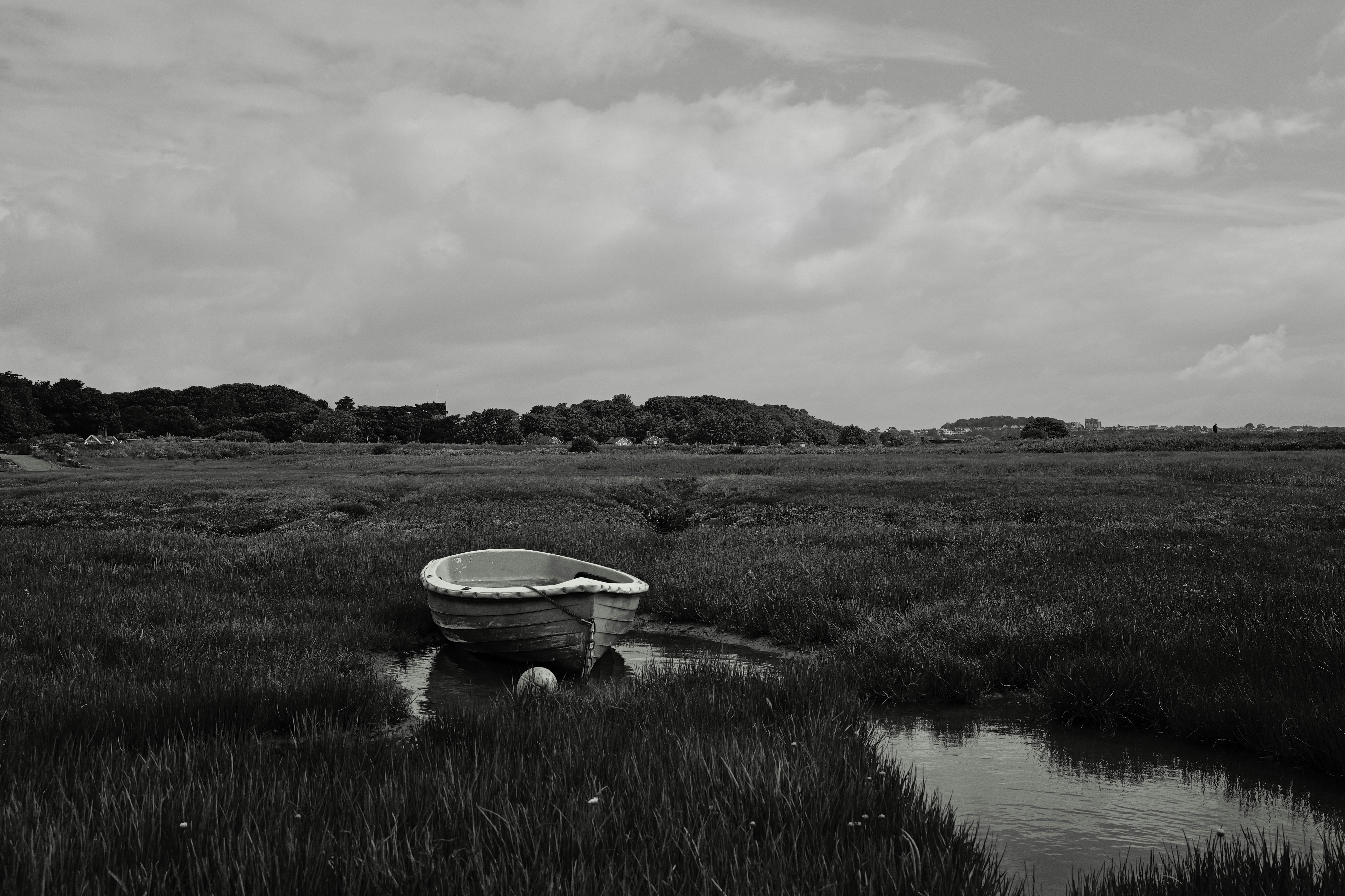 Lone Boat in a Tidal Marsh Under a Quiet, Cloudy Sky