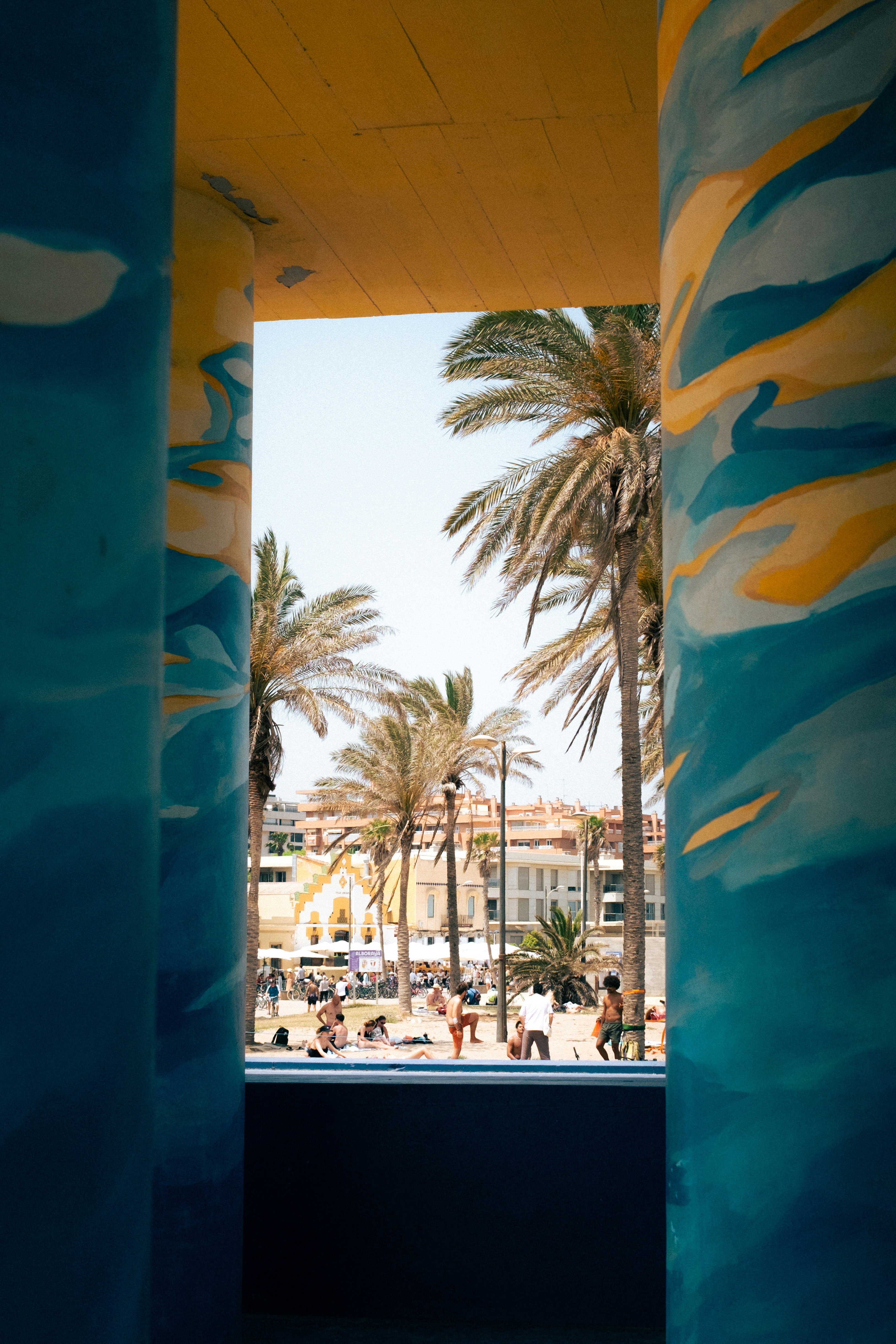Palm-fringed courtyard framed by painted columns