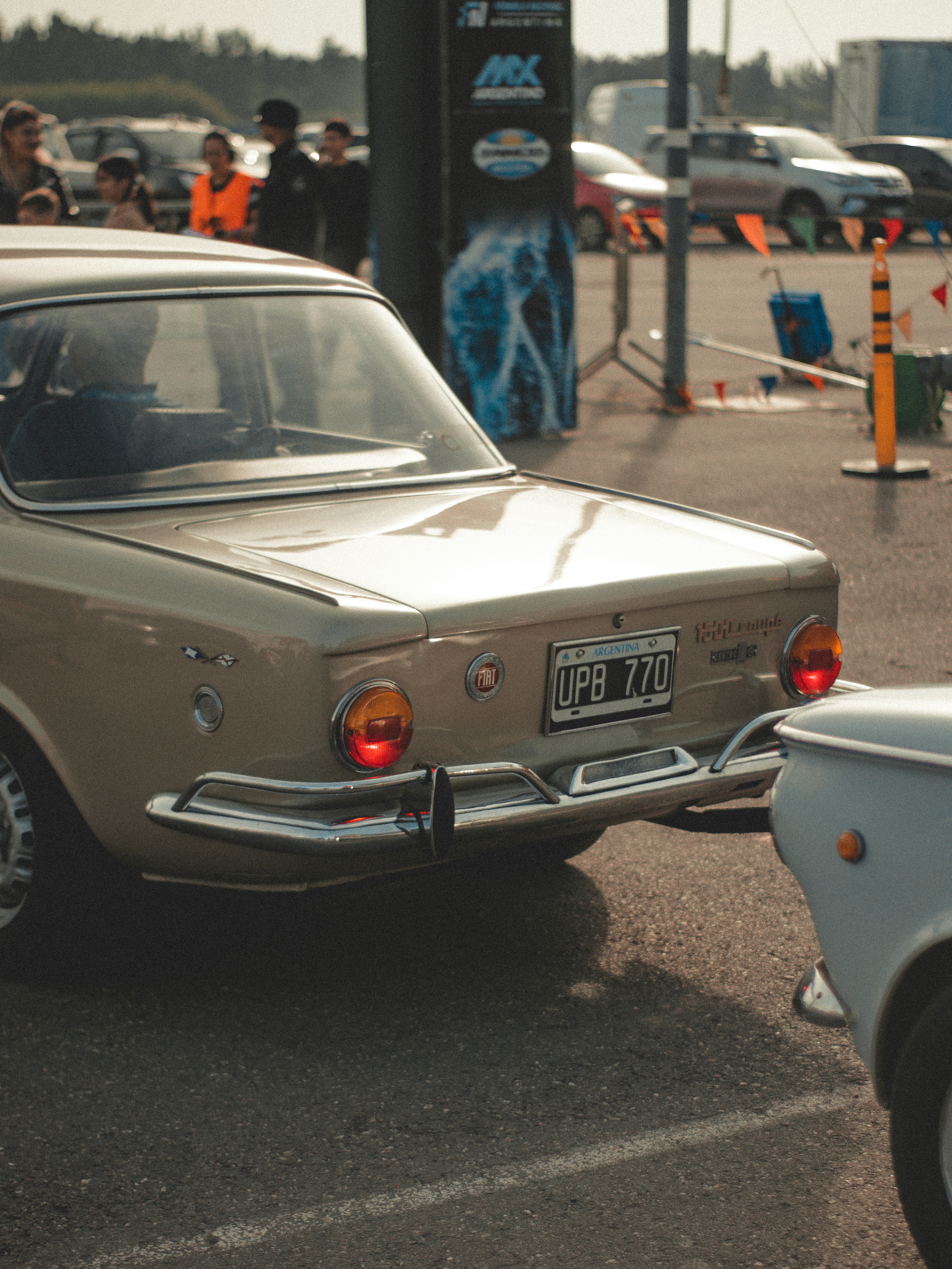 A tan car parked in a parking lot next to other cars photo – Free ...