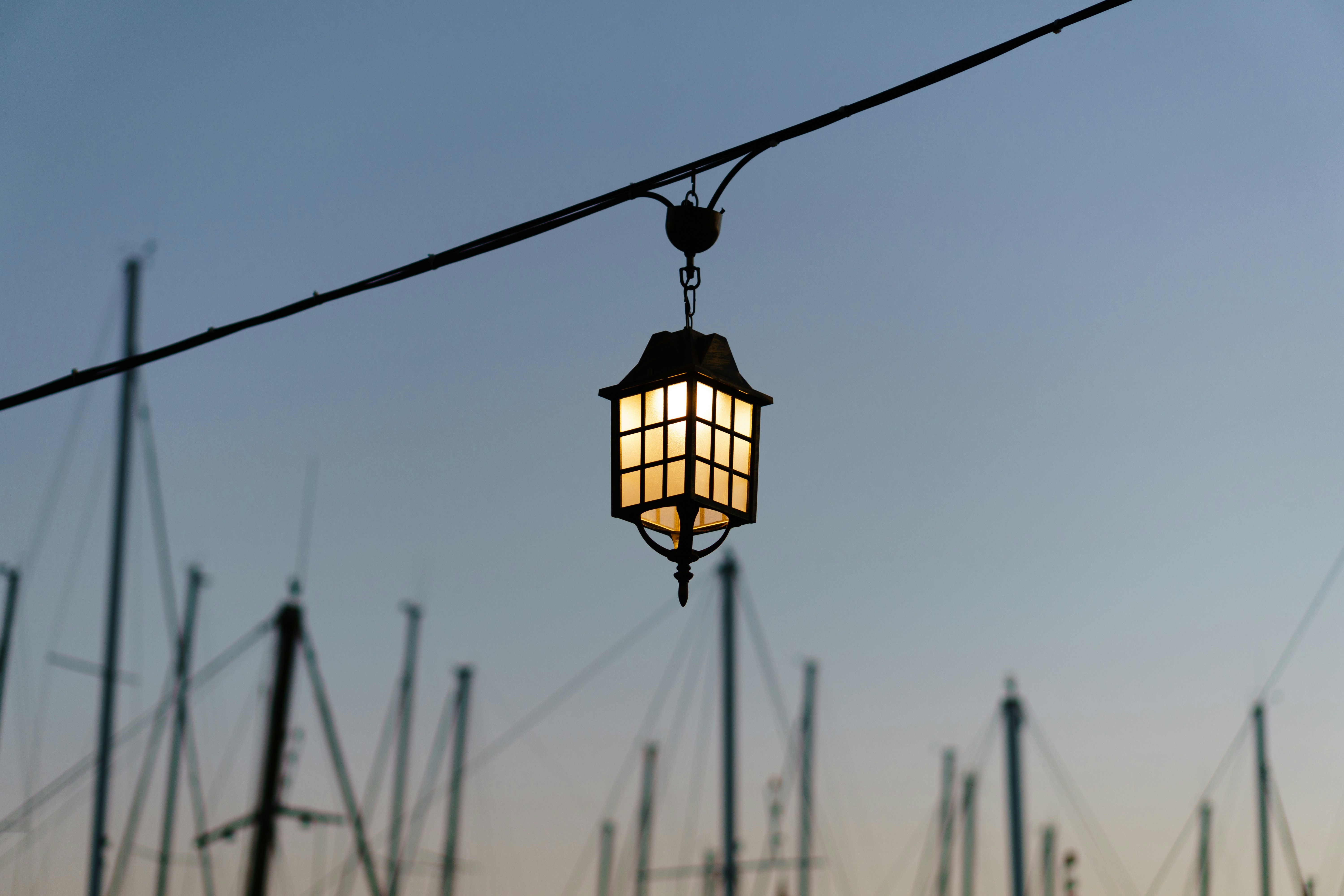 Lantern Over a Marina: Warm Glow Between Sails
