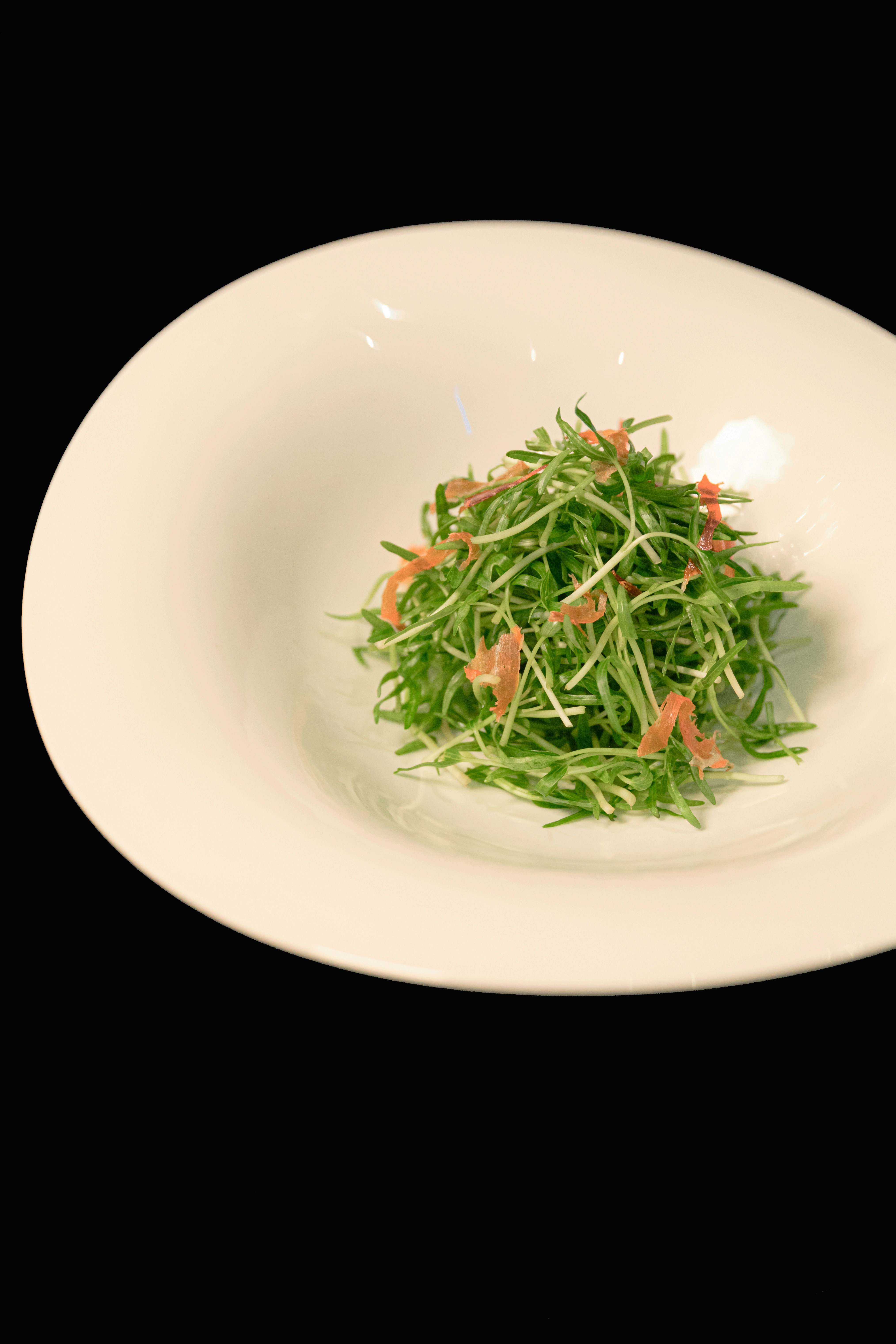 Citrus-green salad nest resting in a pale shell