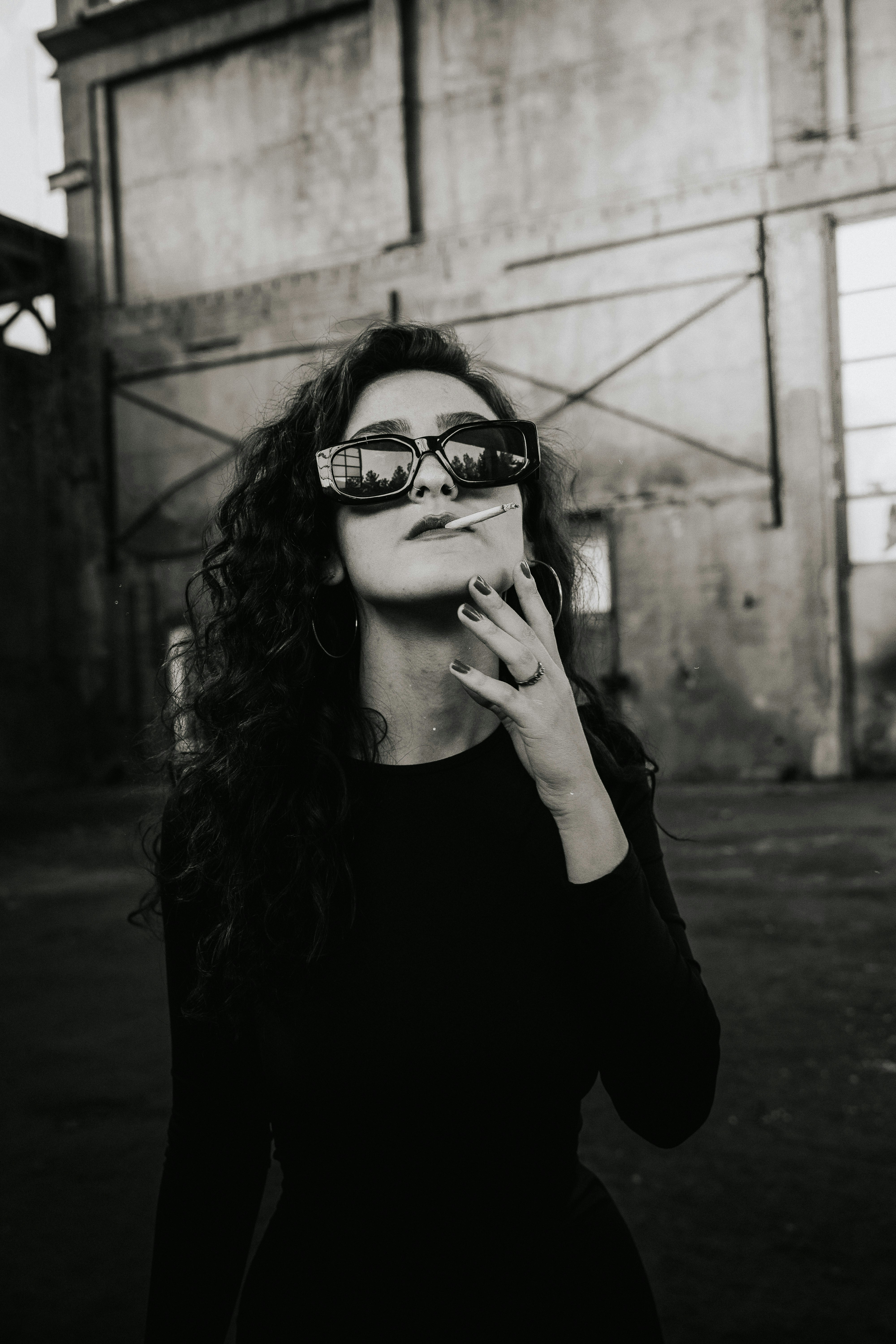 Smoke and Steel: A Portrait of Quiet Rebellion Amid Rusted Walls