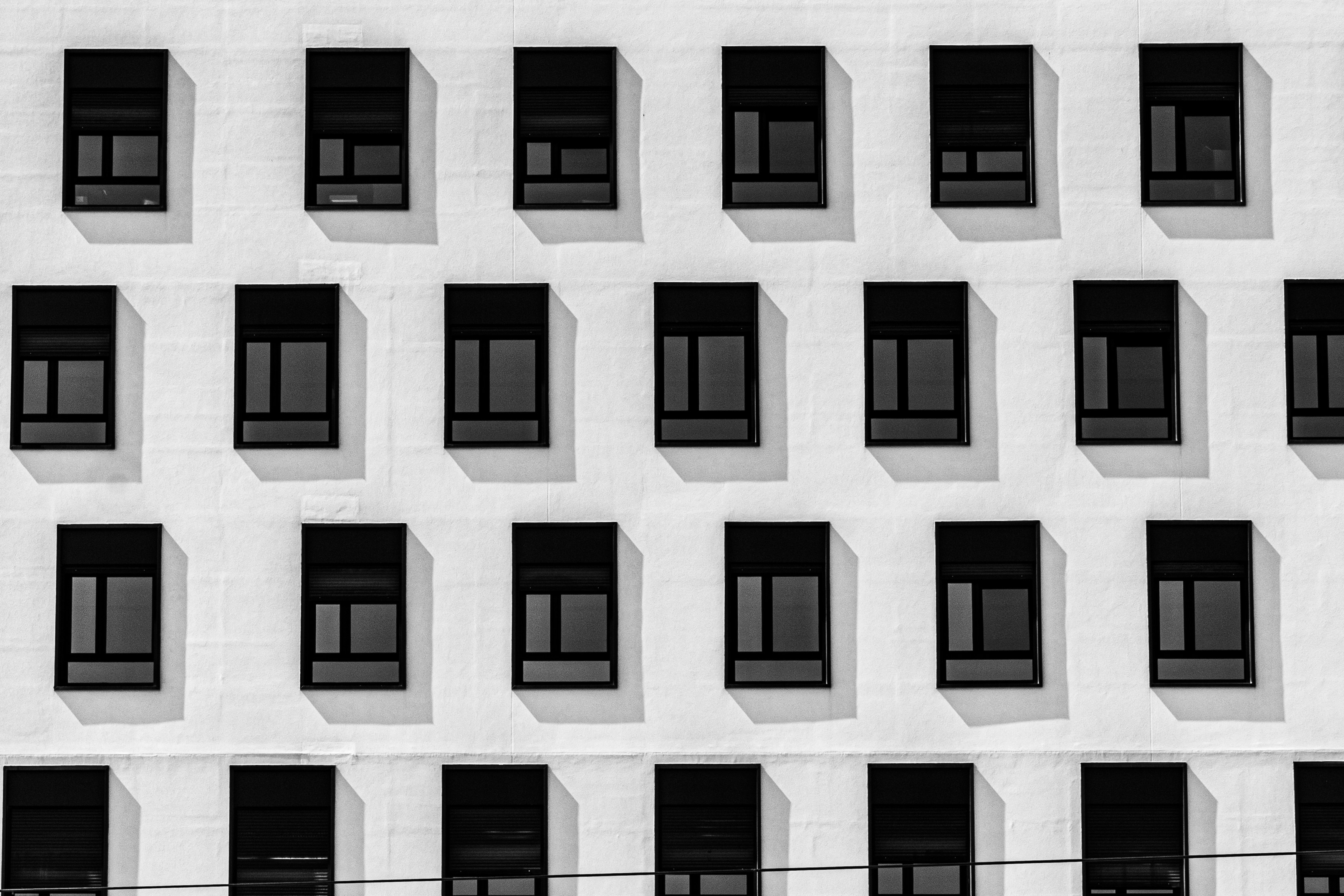 A black and white photo of a building with many windows photo – Free ...