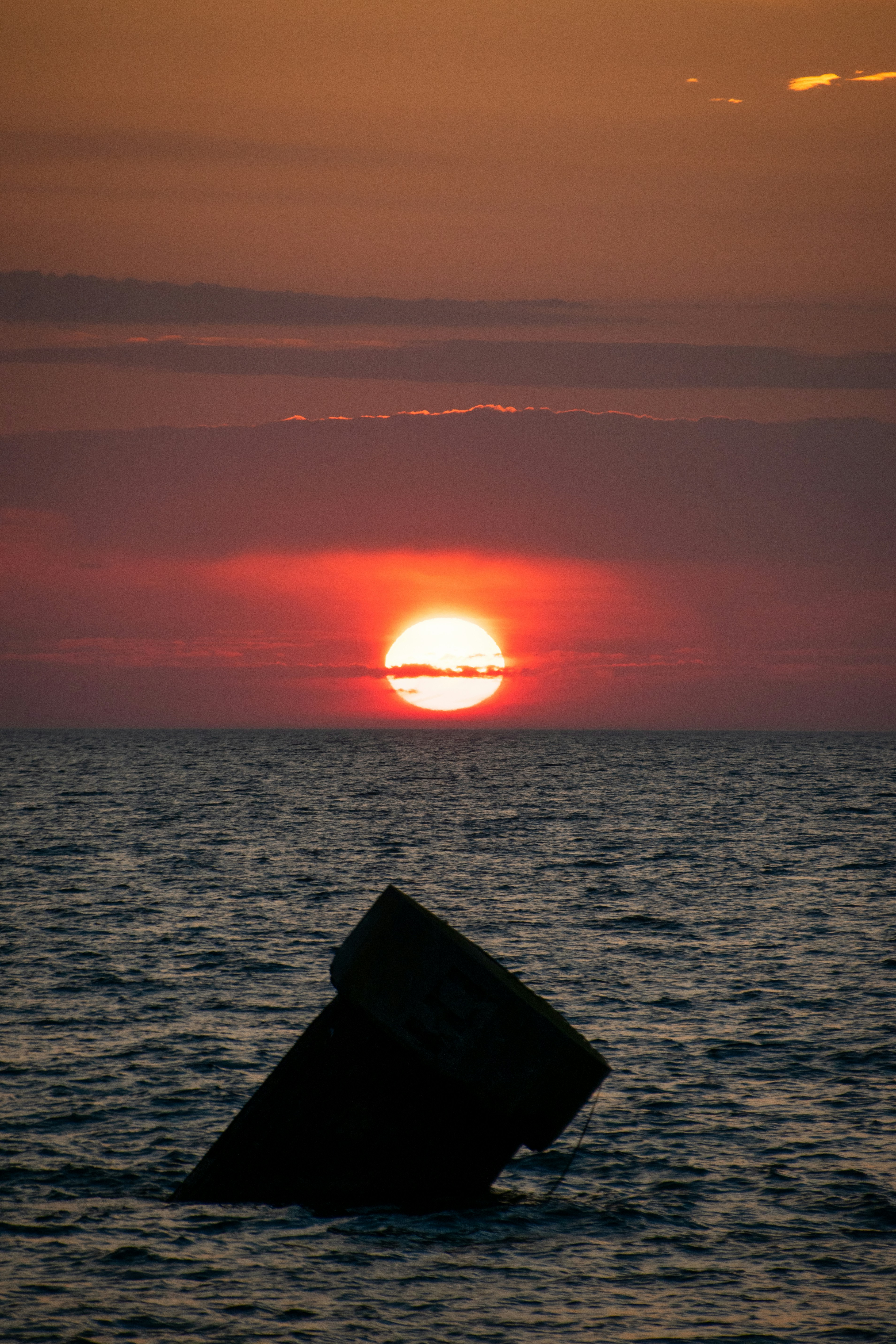 Crimson Horizon: A Tilted Silhouette at Dusk