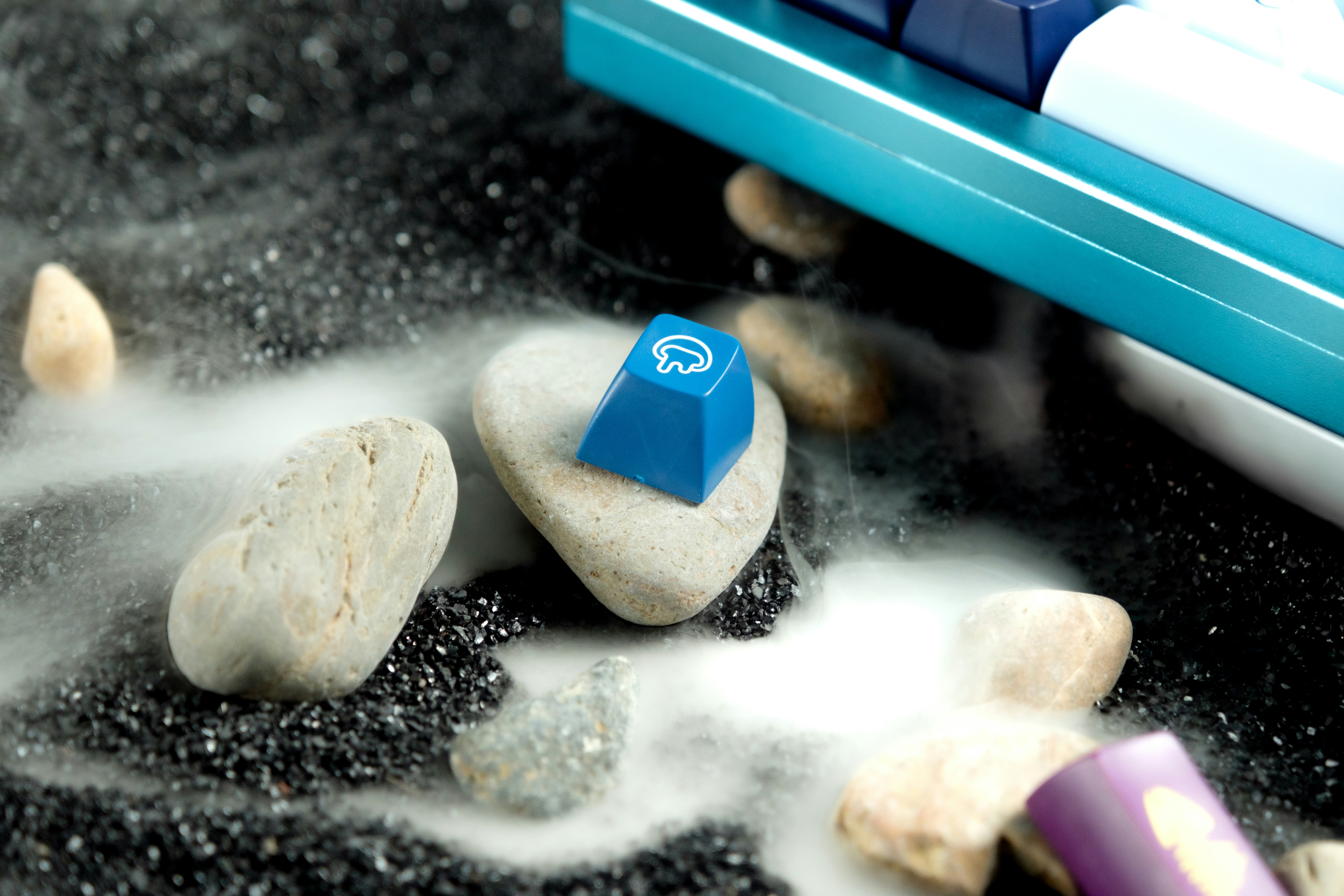 A blue computer keyboard sitting on top of a pile of rocks photo – Free ...