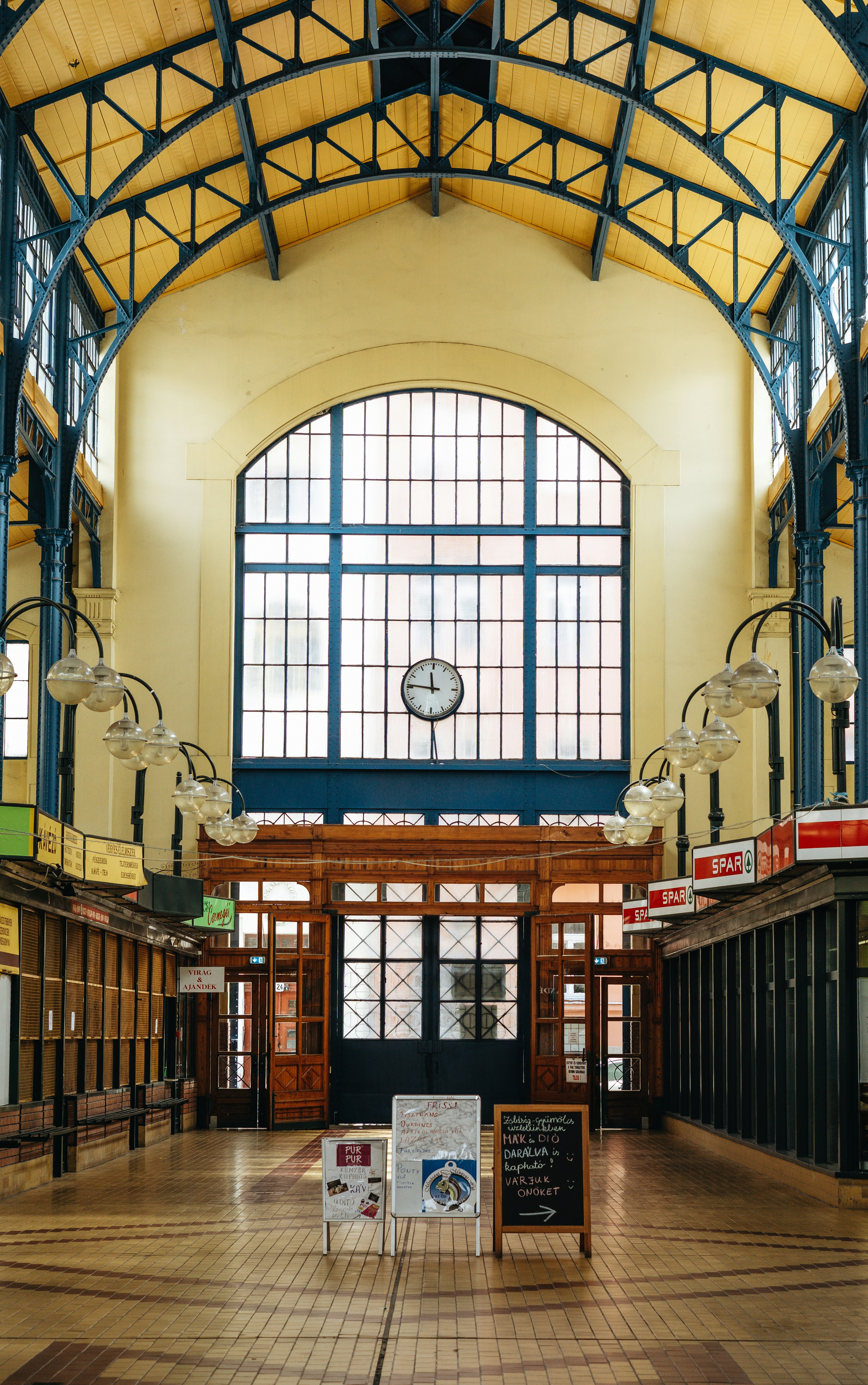 Clock in the Arch: Sunlit Market Hall Framed by Blue Steel
