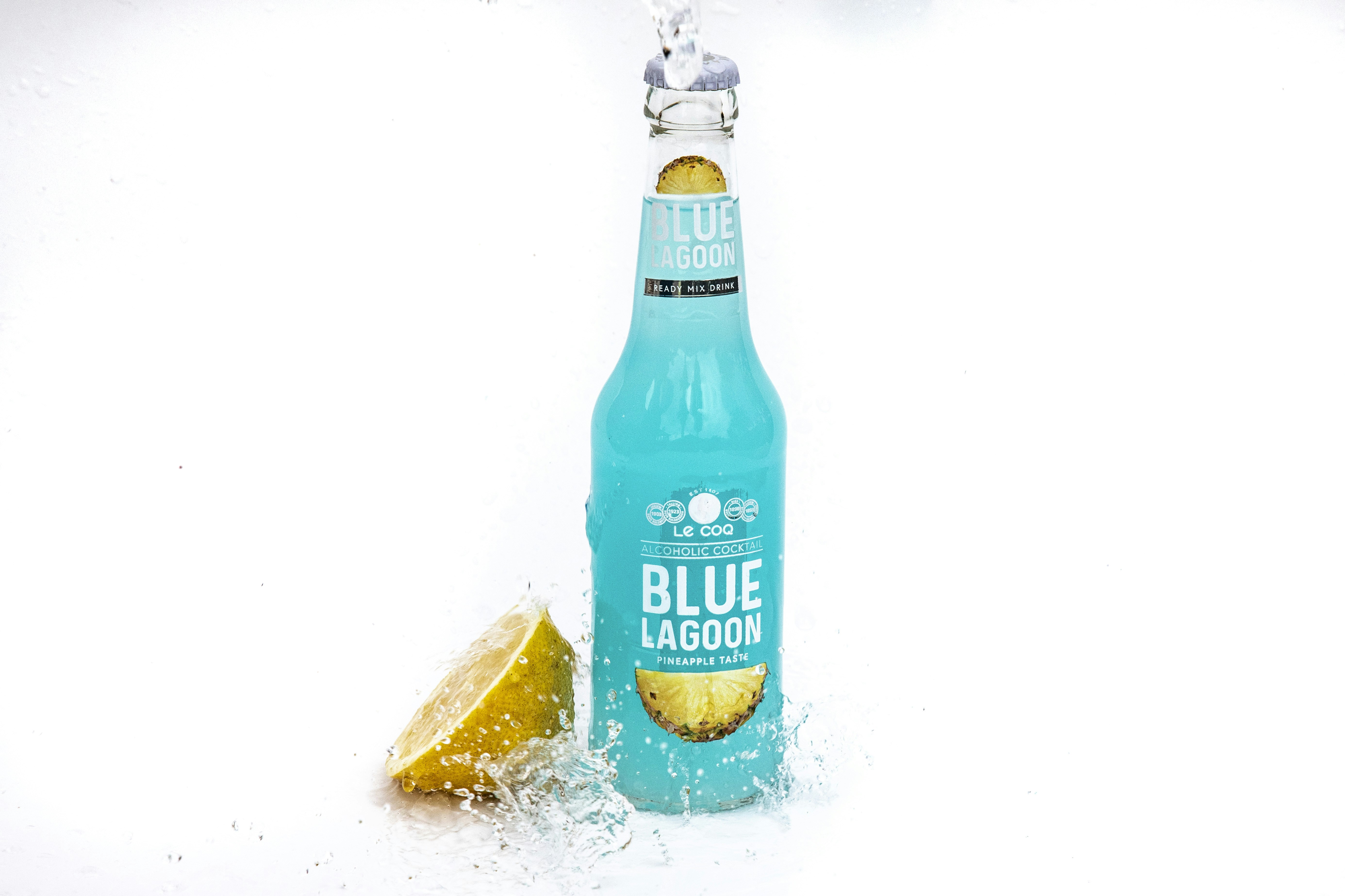 A bottle of blue lagoon next to a slice of lemon photo – Free Nettuno ...