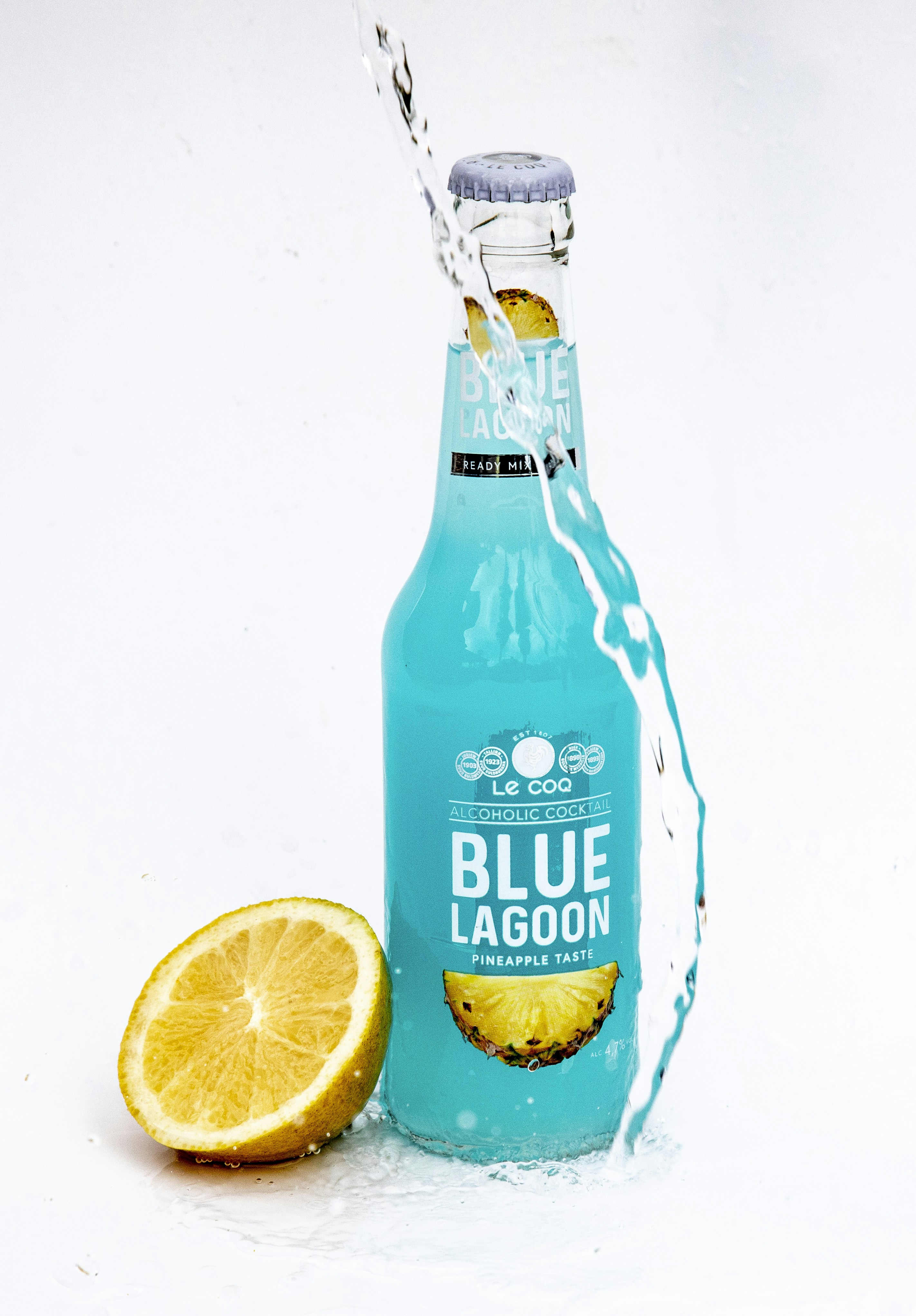 A bottle of blue lagoon next to a sliced lemon photo – Free Rm Image on ...