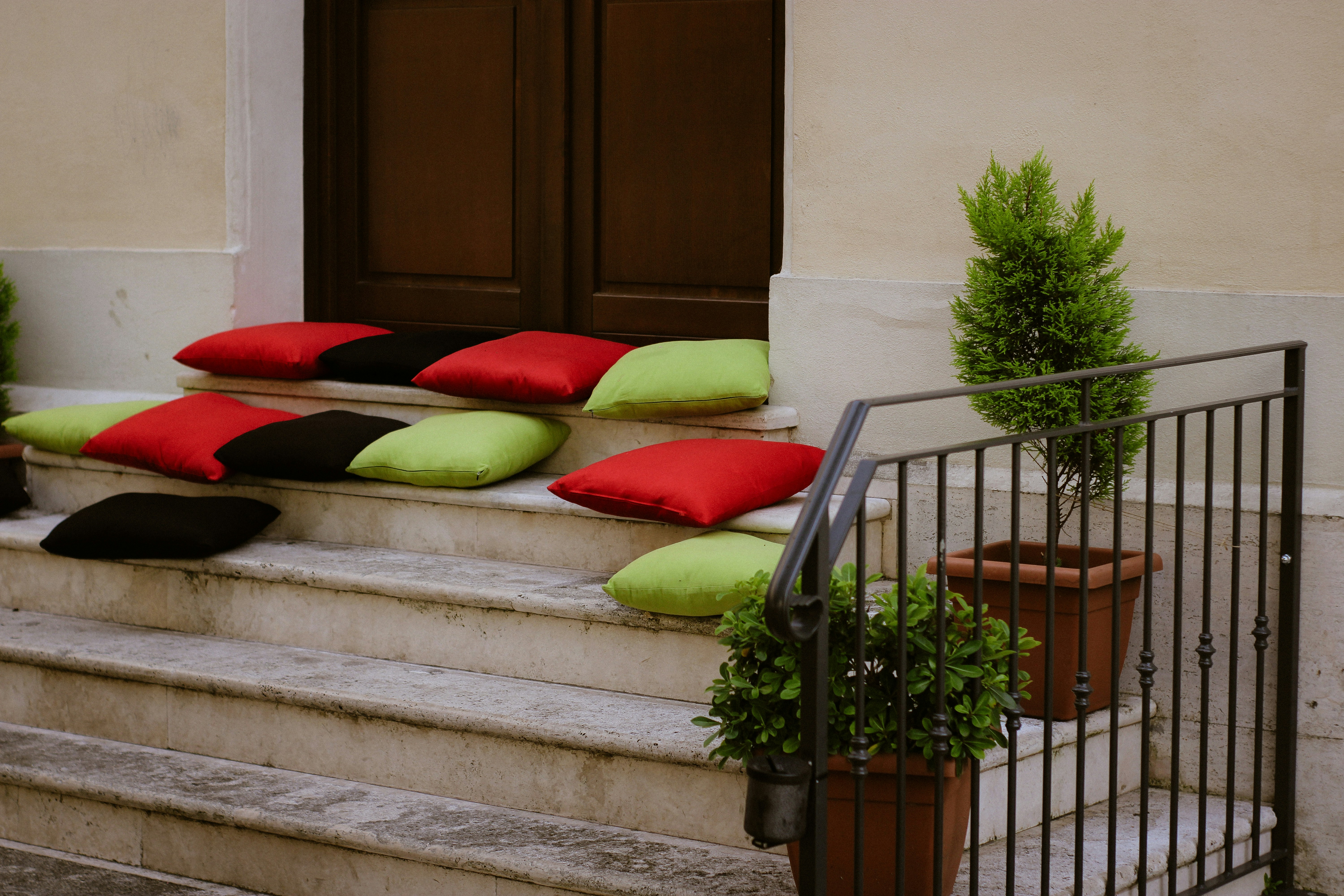 A bunch of pillows sitting on the steps of a building photo – Free ...