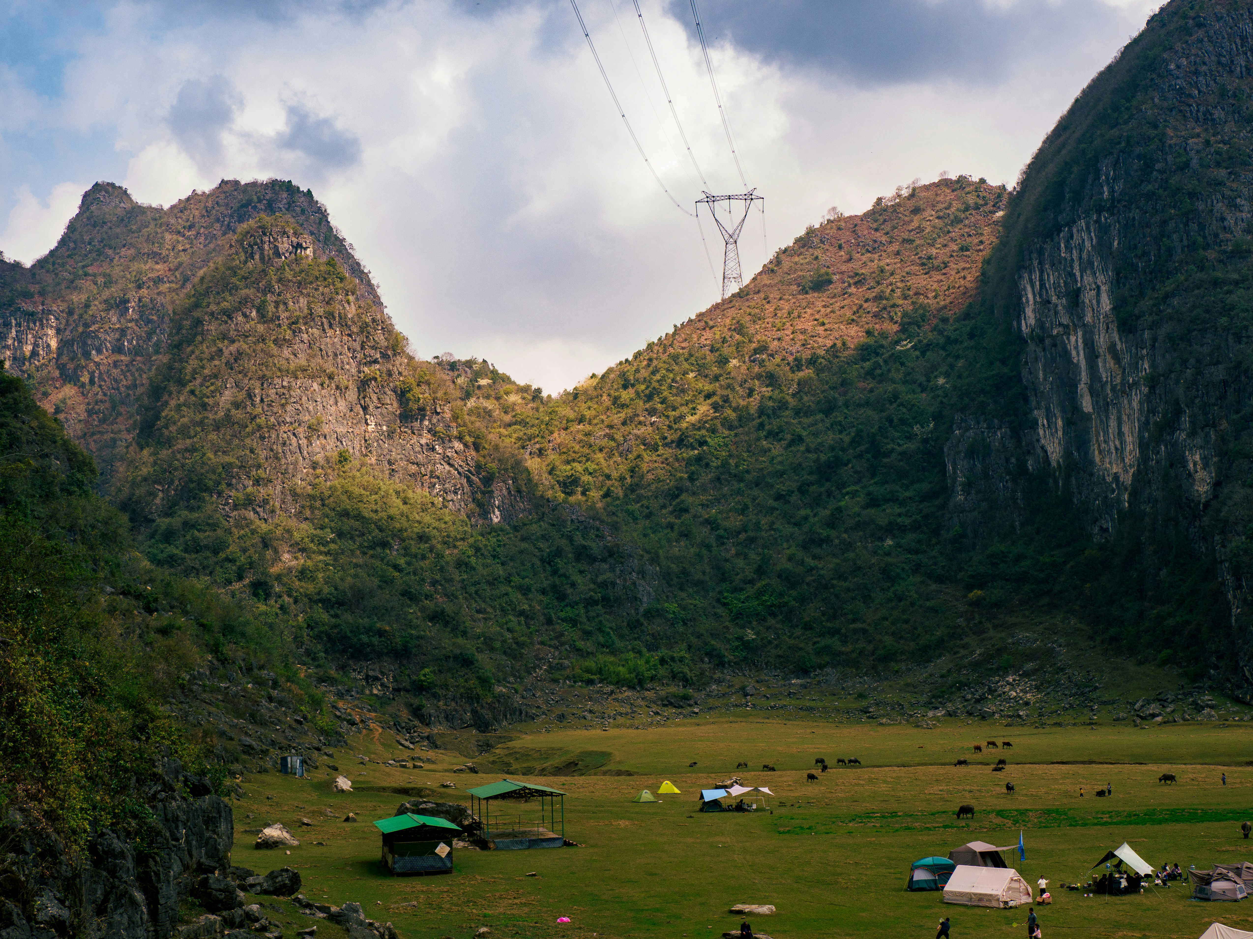 Quiet Camp Beneath a Looming Pylon in a Mountain Valley
