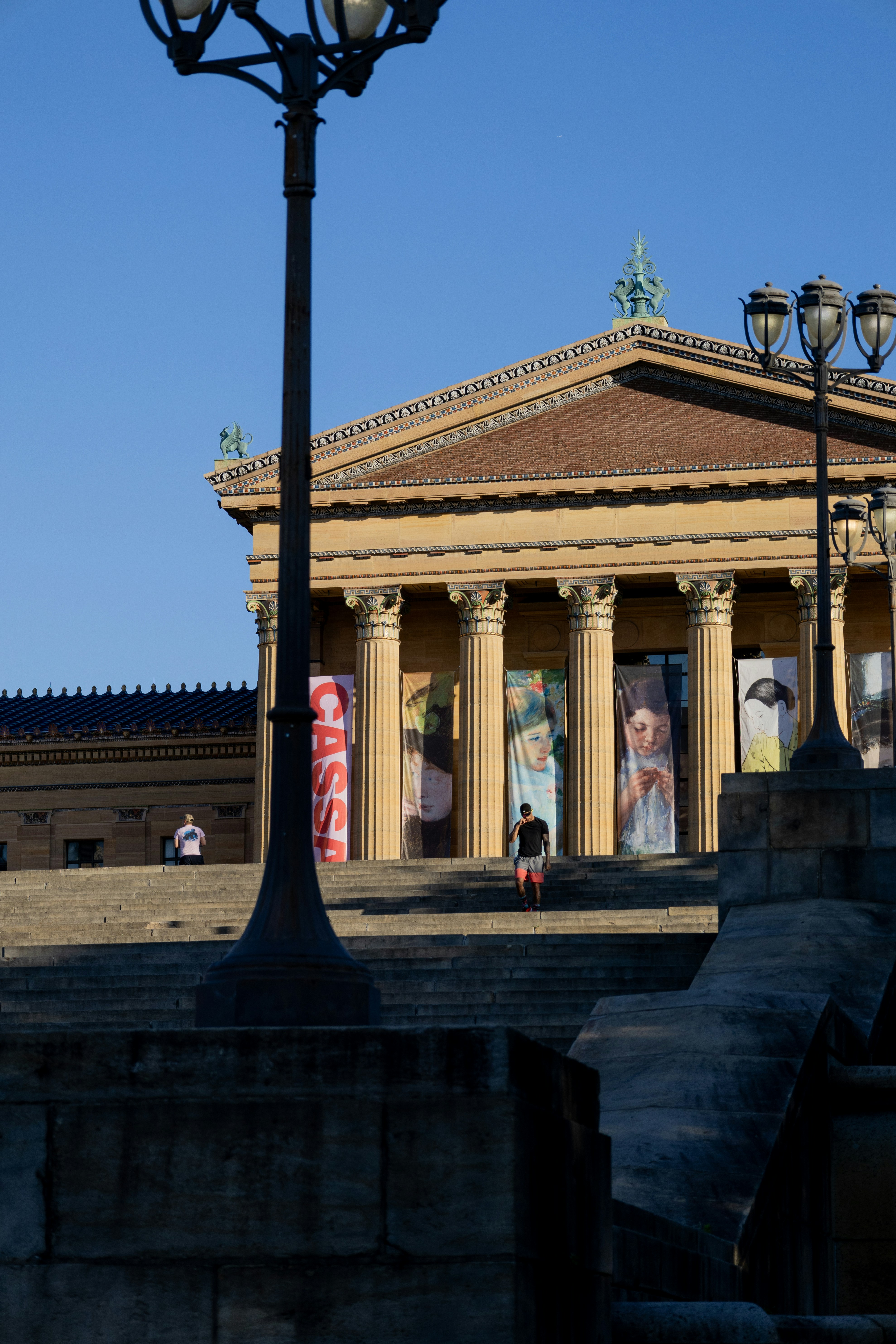 Blue Sky over a Colonnaded Museum Framed by Street Lamps