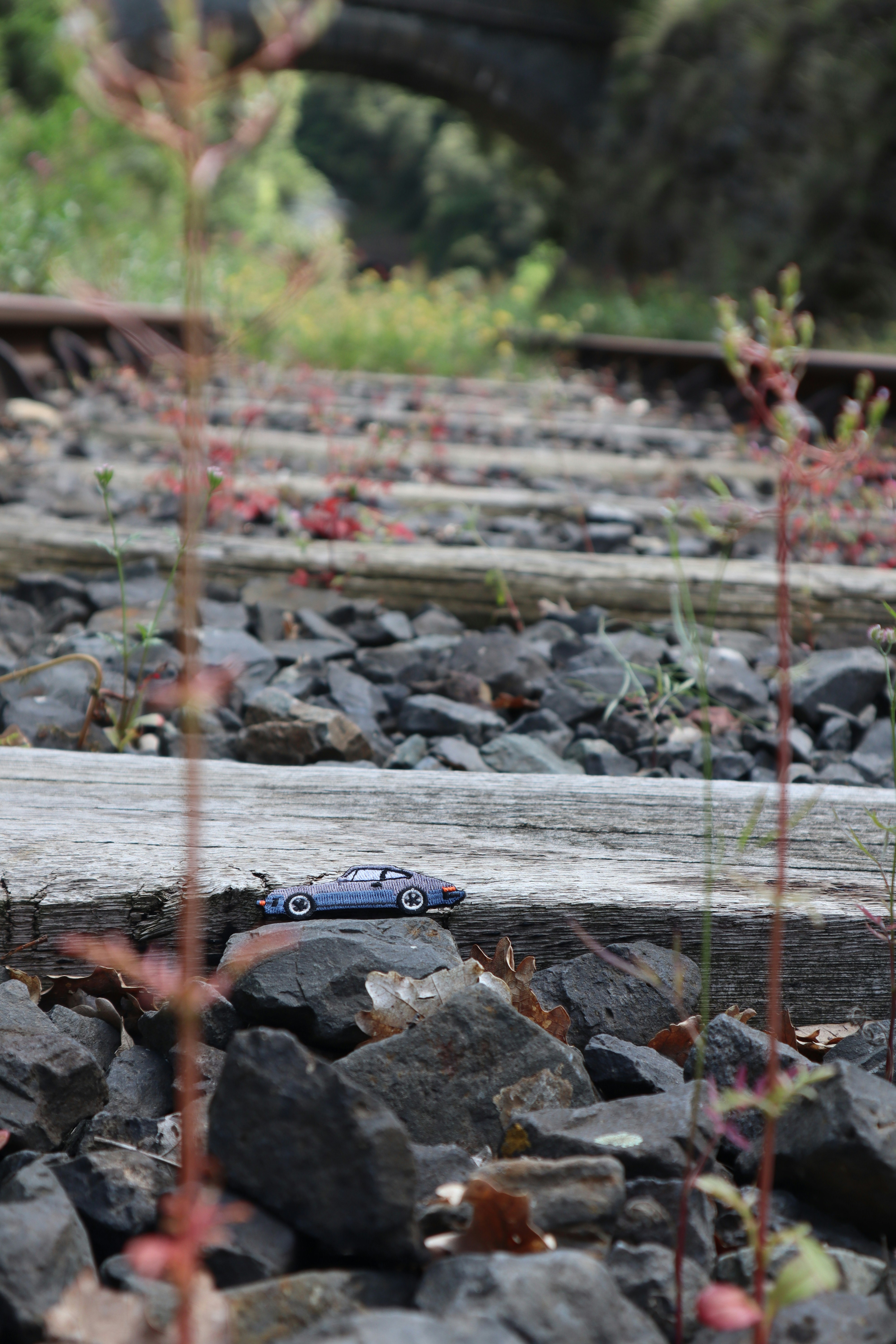 Tiny Racer on a Weathered Rail Bed: A Ground-Level Micro Scene