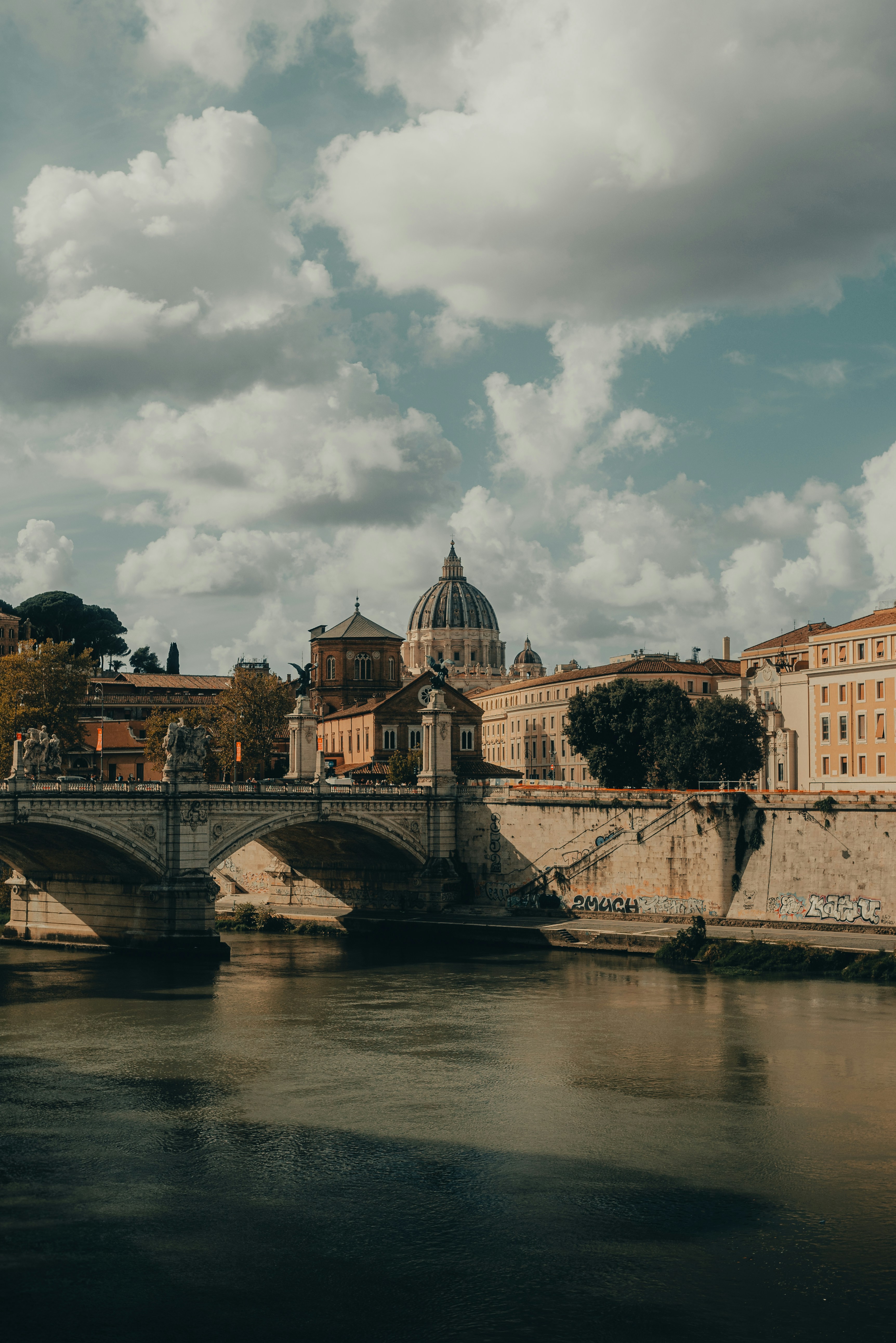 A bridge over a river with buildings in the background photo – Free ...