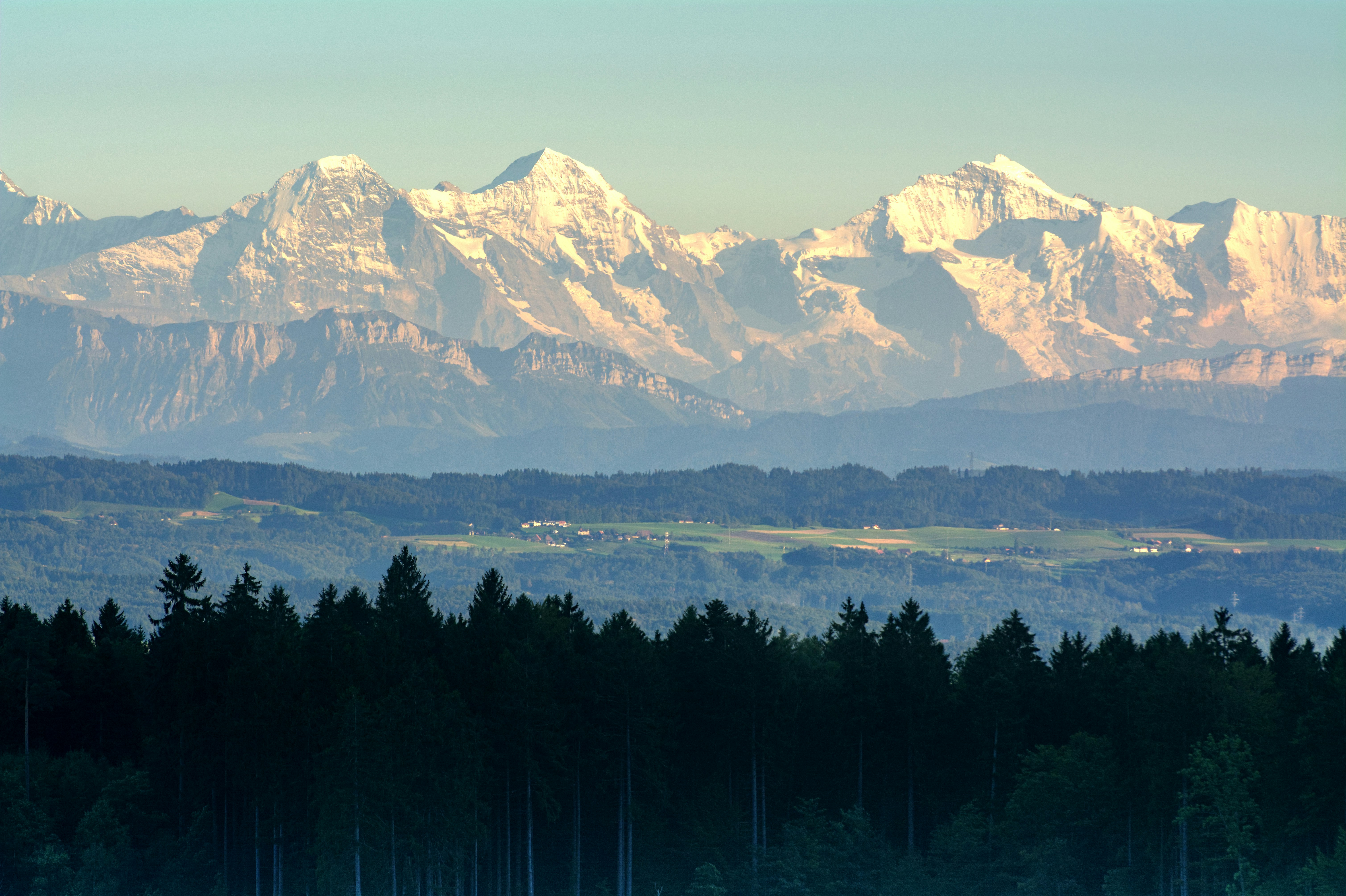 A view of a mountain range with trees in the foreground photo – Free ...