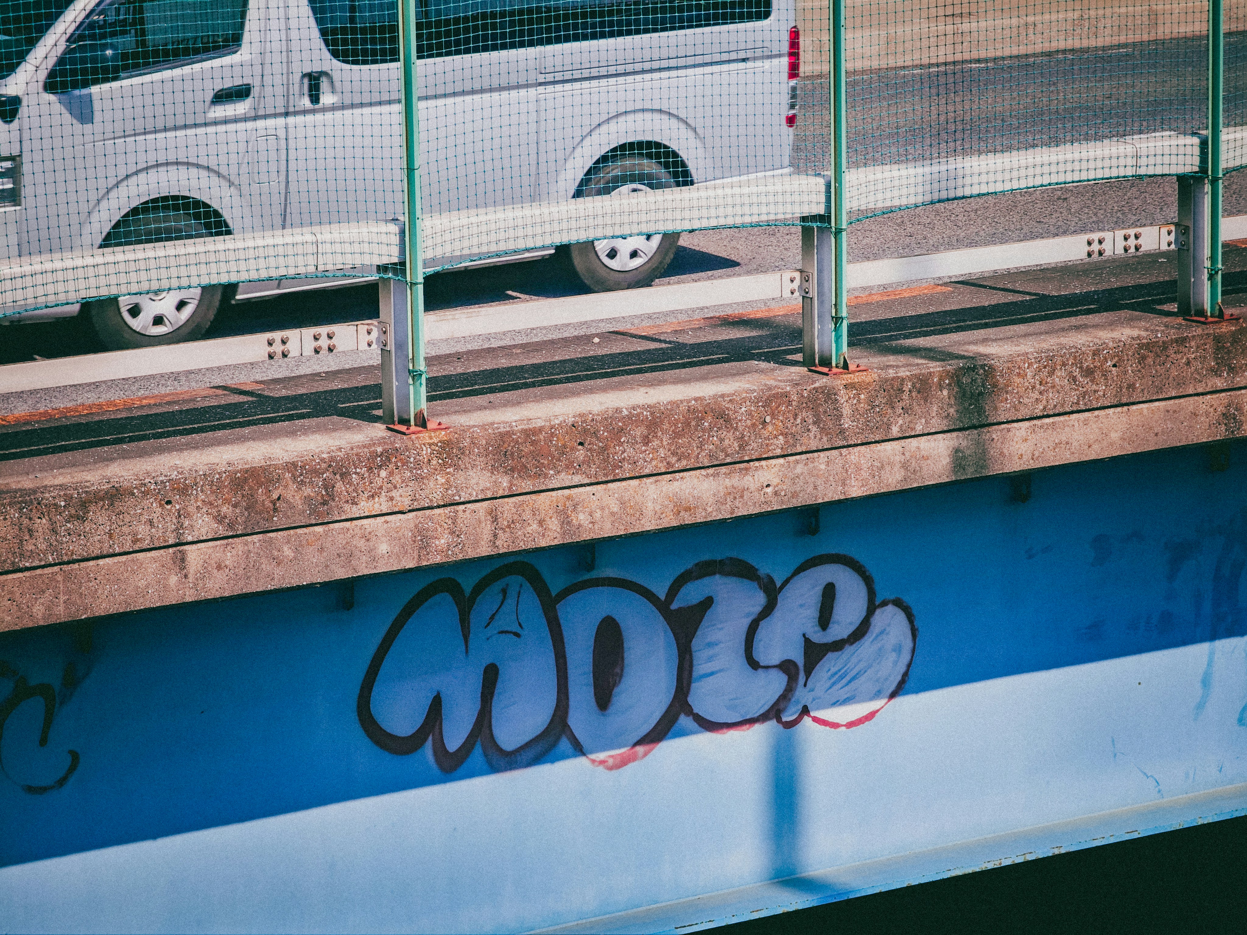 Vibrant graffiti art displayed on a bridge, contrasting with the muted tones of the surrounding urban environment. The scene captures the essence of street culture.