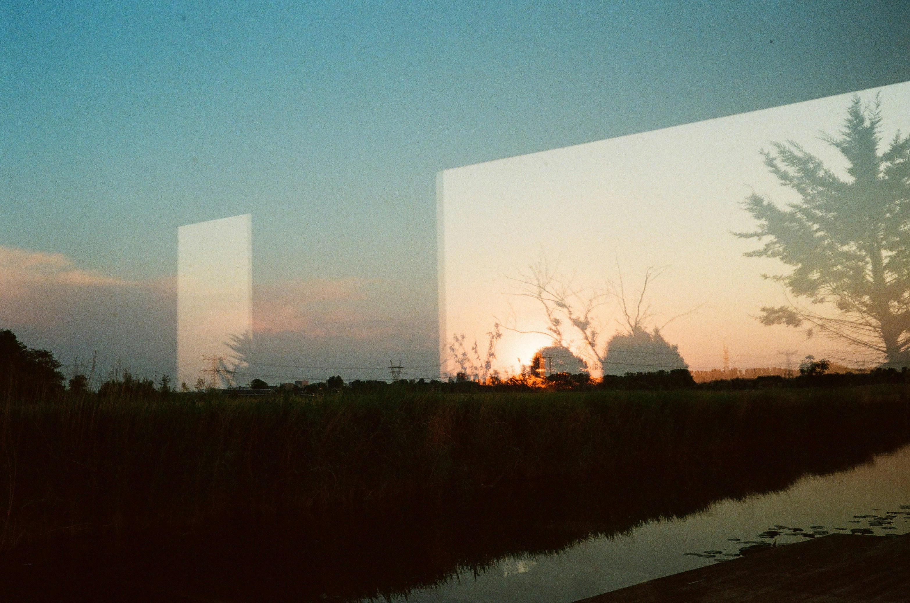 Horizon Echoes: Sunset Over a Marsh with Ghost Window Reflections