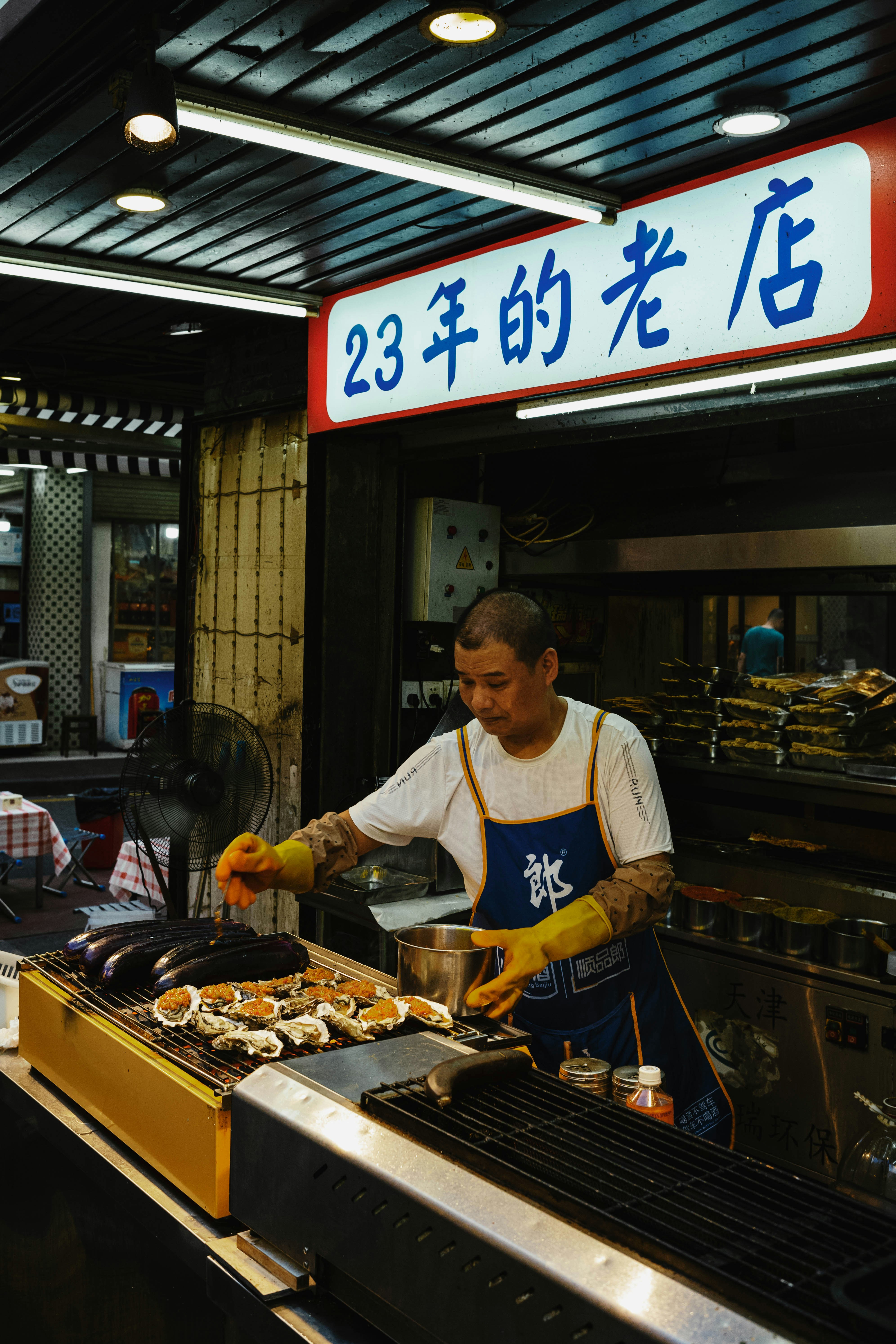 A man cooking food on a grill in a restaurant photo – Free Human Image ...